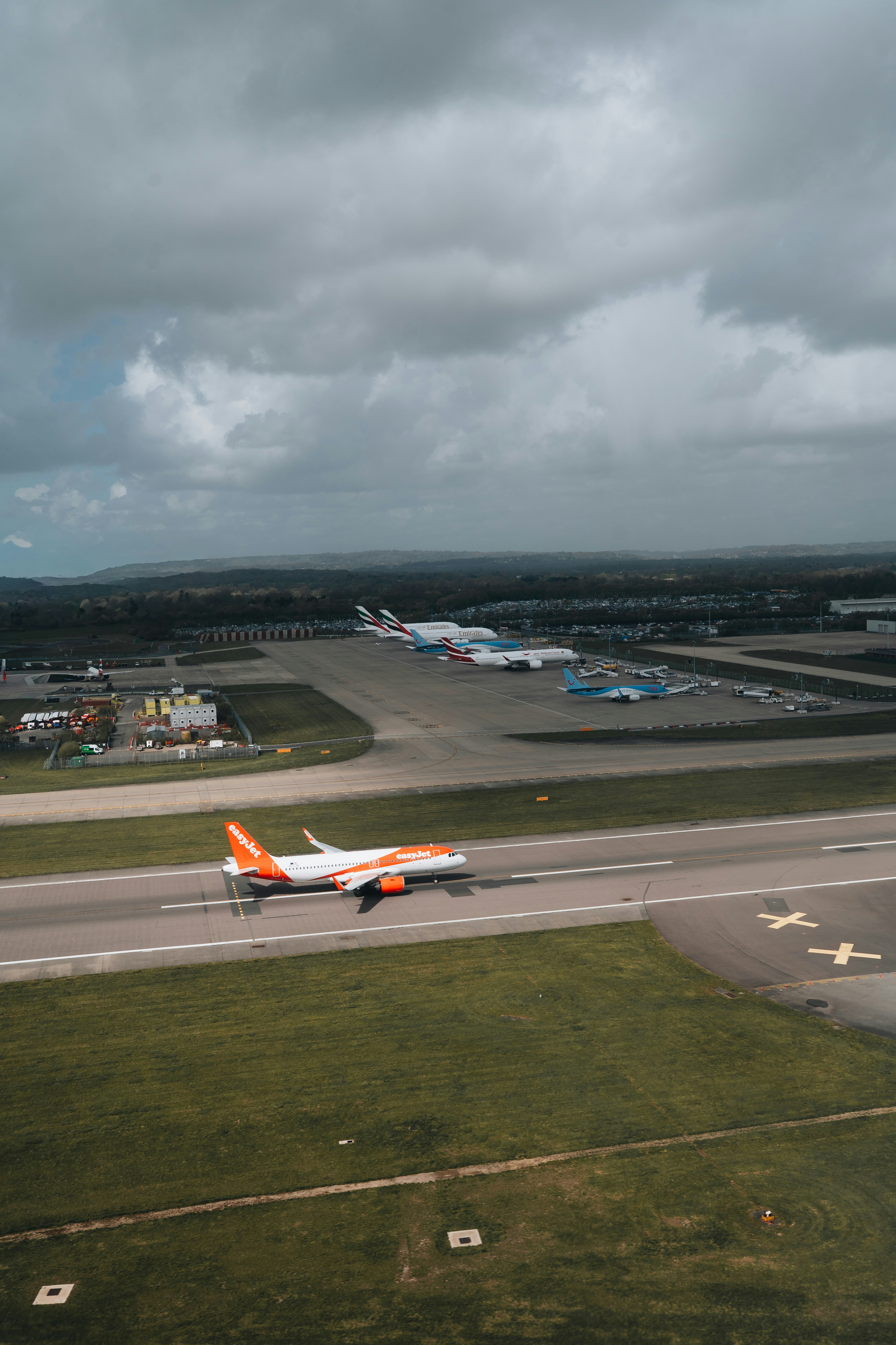 Orange Jet on a Quiet Taxiway Under Wide Sky