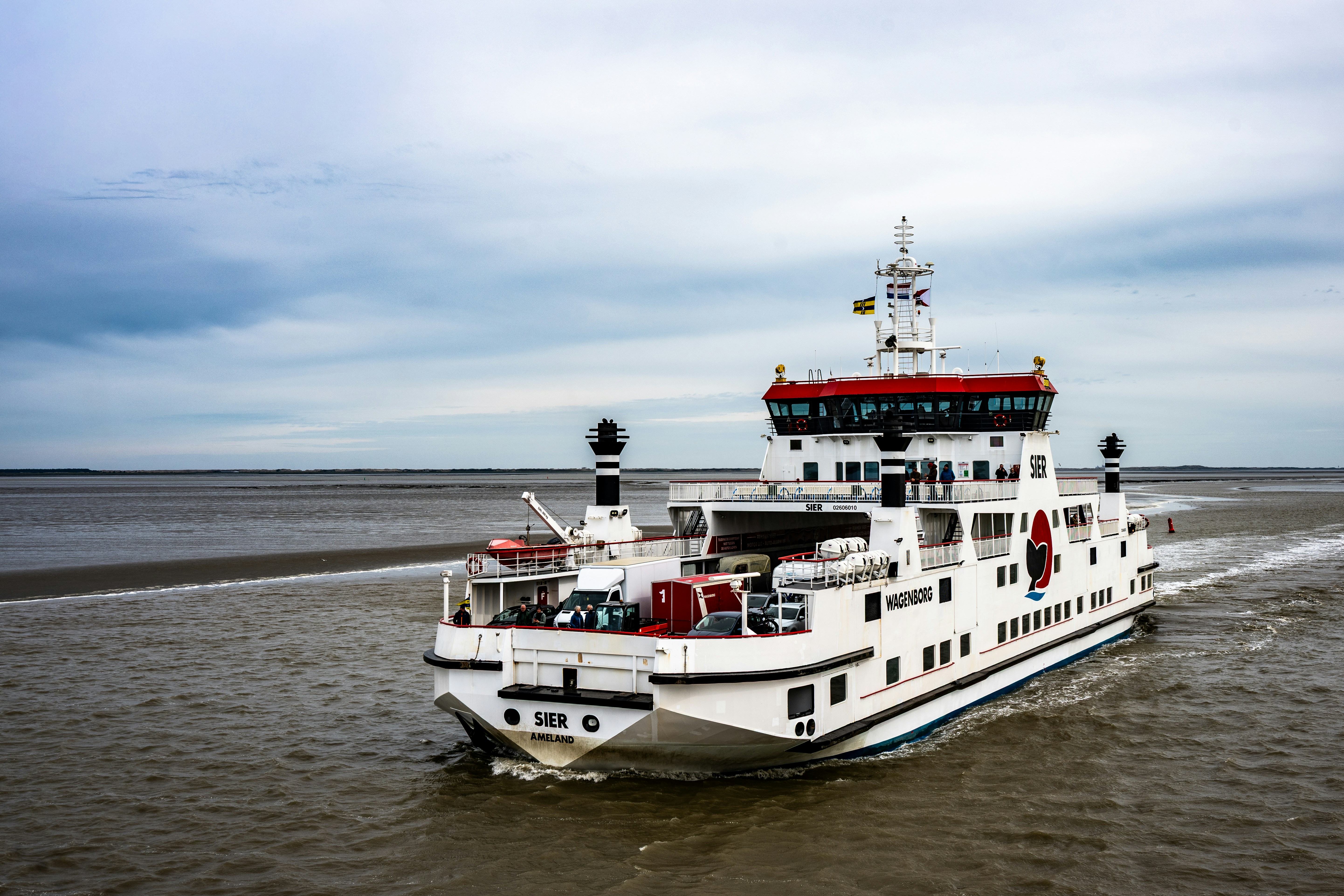 Midday Ferry Adrift: A White Vessel Traverses Tidal Mloom