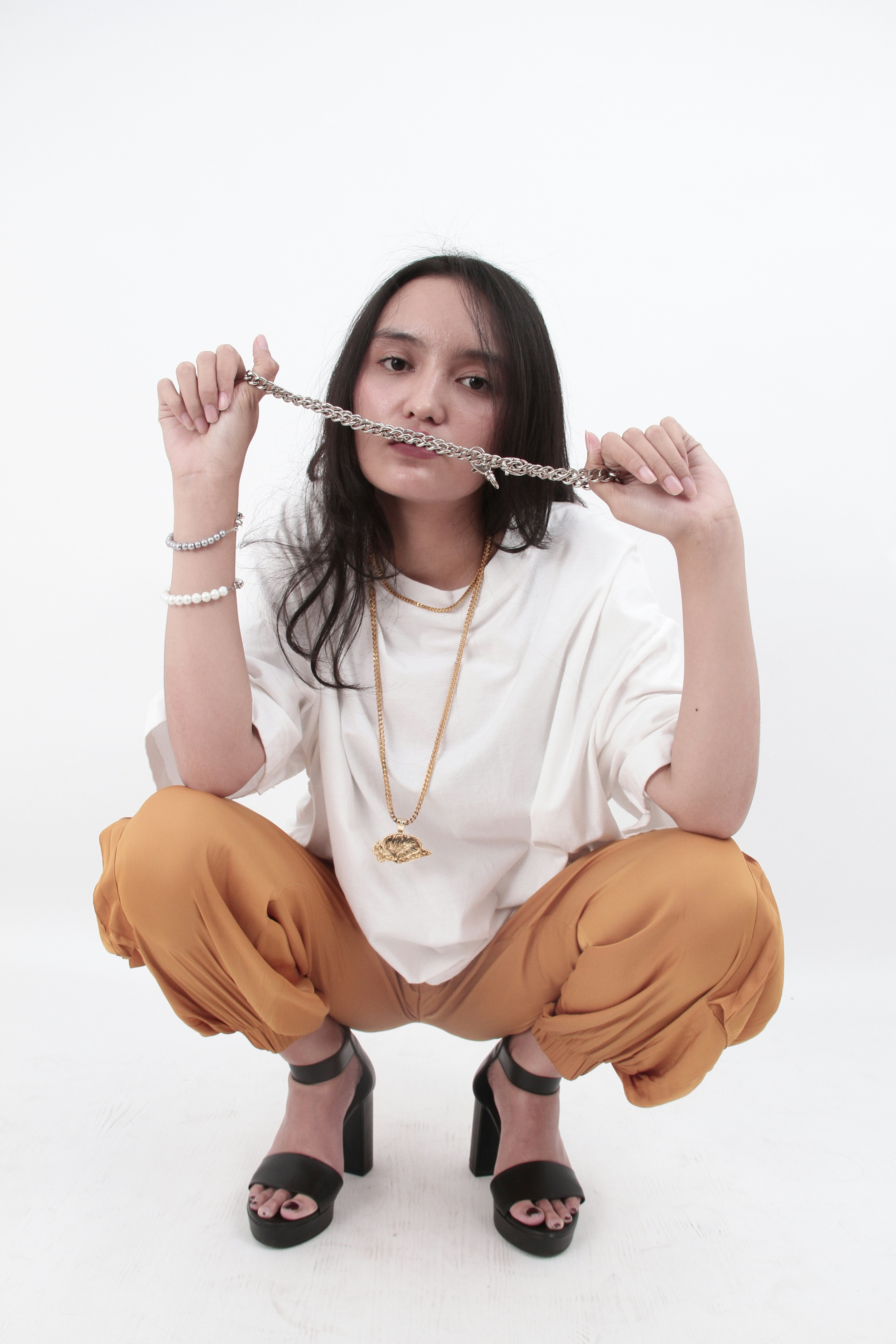 Chain Whisperer: A Crouched Portrait with Jewelry Dialogue