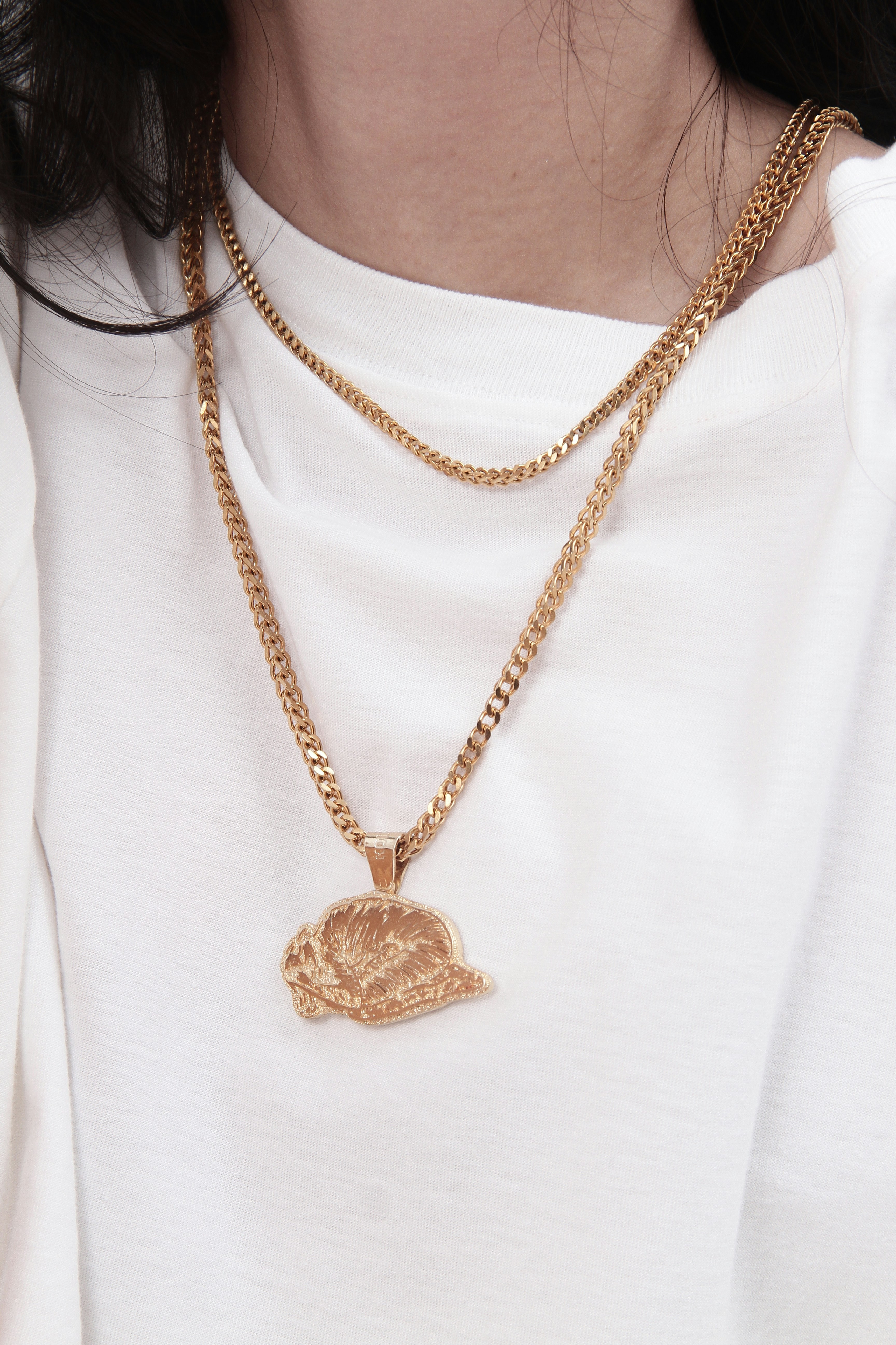 Gold Heartbeat: A Close-Up of a Lush Necklace Against White Fabric
