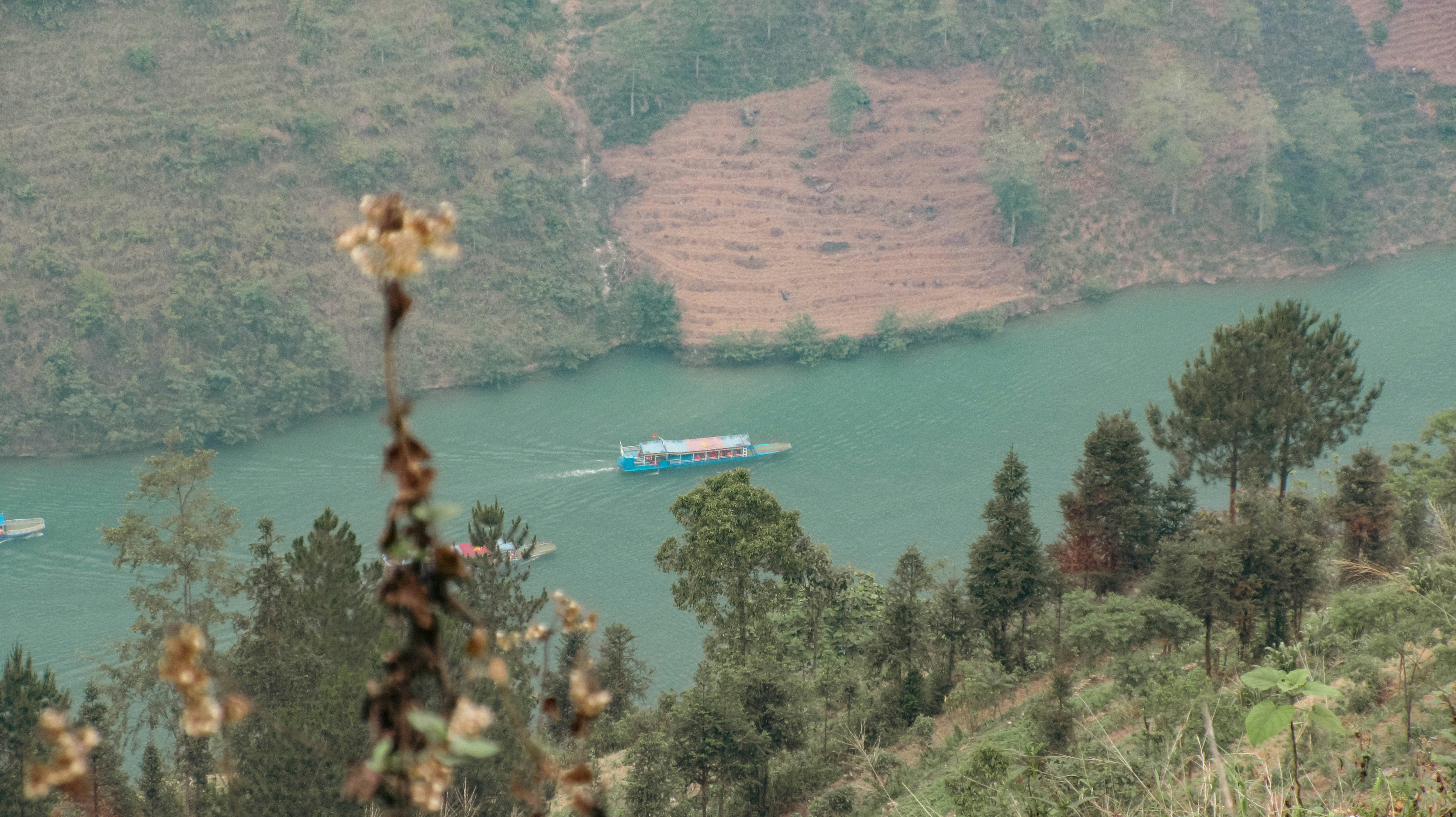 River Route: A turquoise band of water meanders past a tree-lined hillside