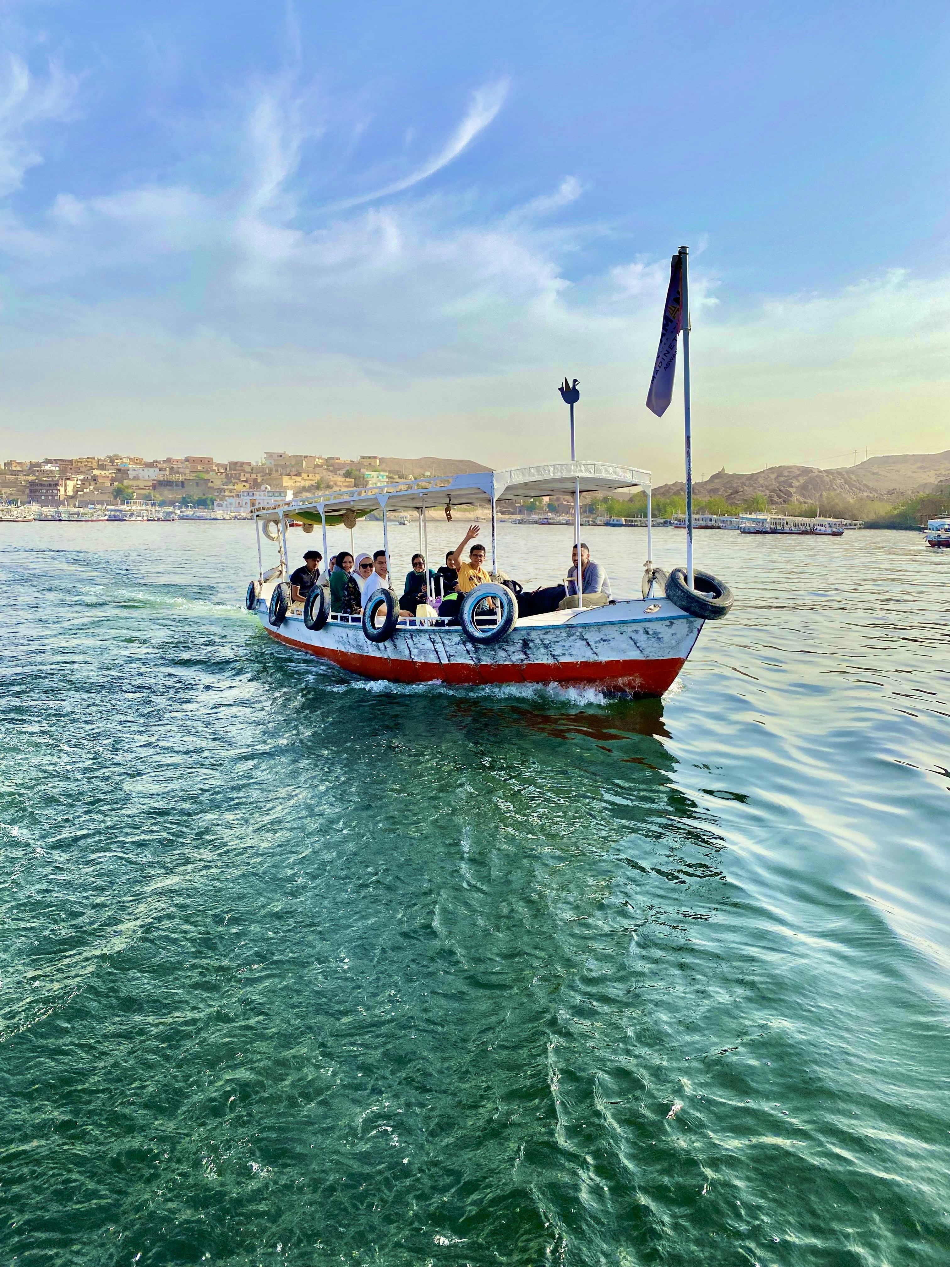 Sunlit Vespa of the Sea: A Passenger Boat Gliding Toward the Horizon
