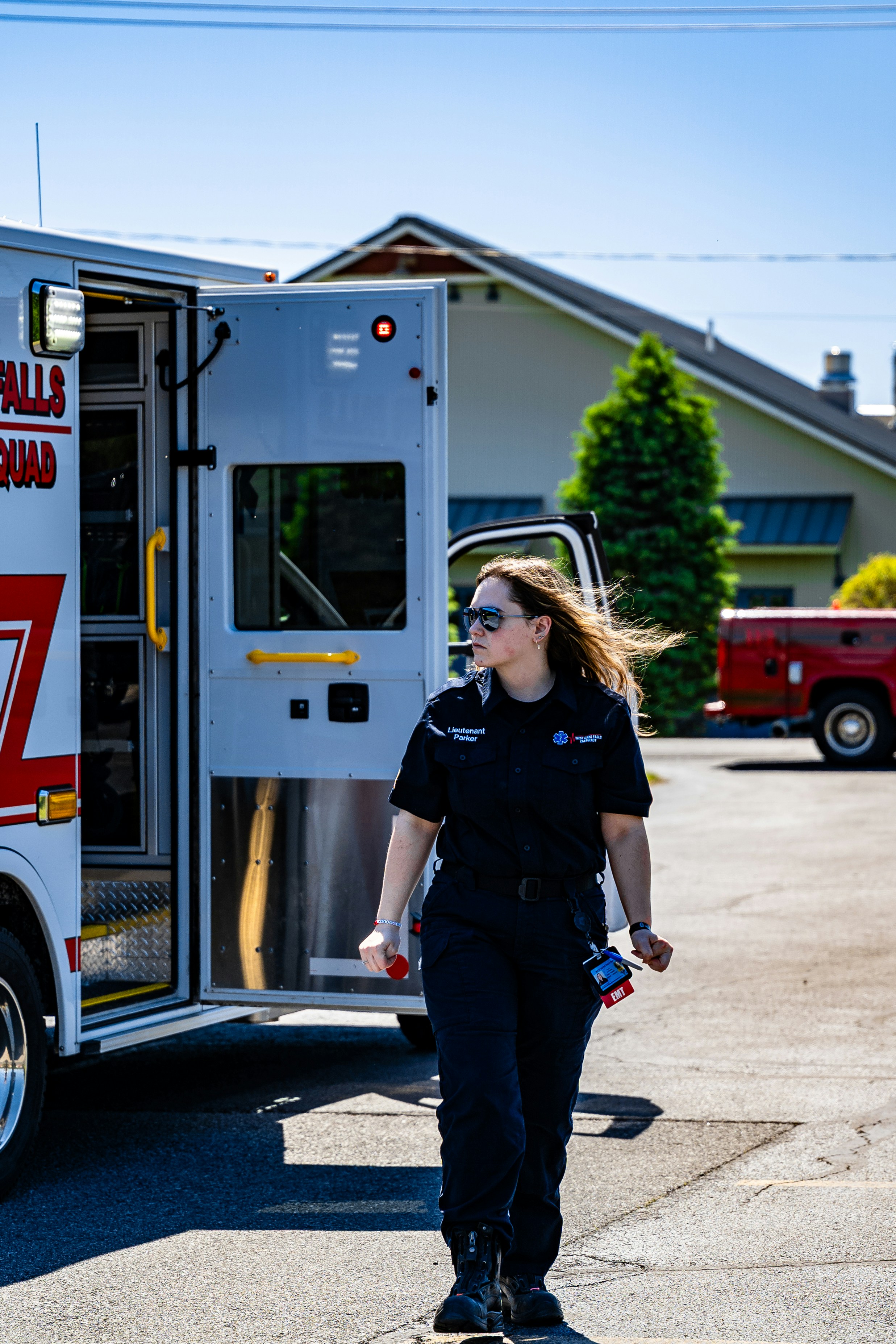 Emergency escort: a responder steps from the ambulance into daylight