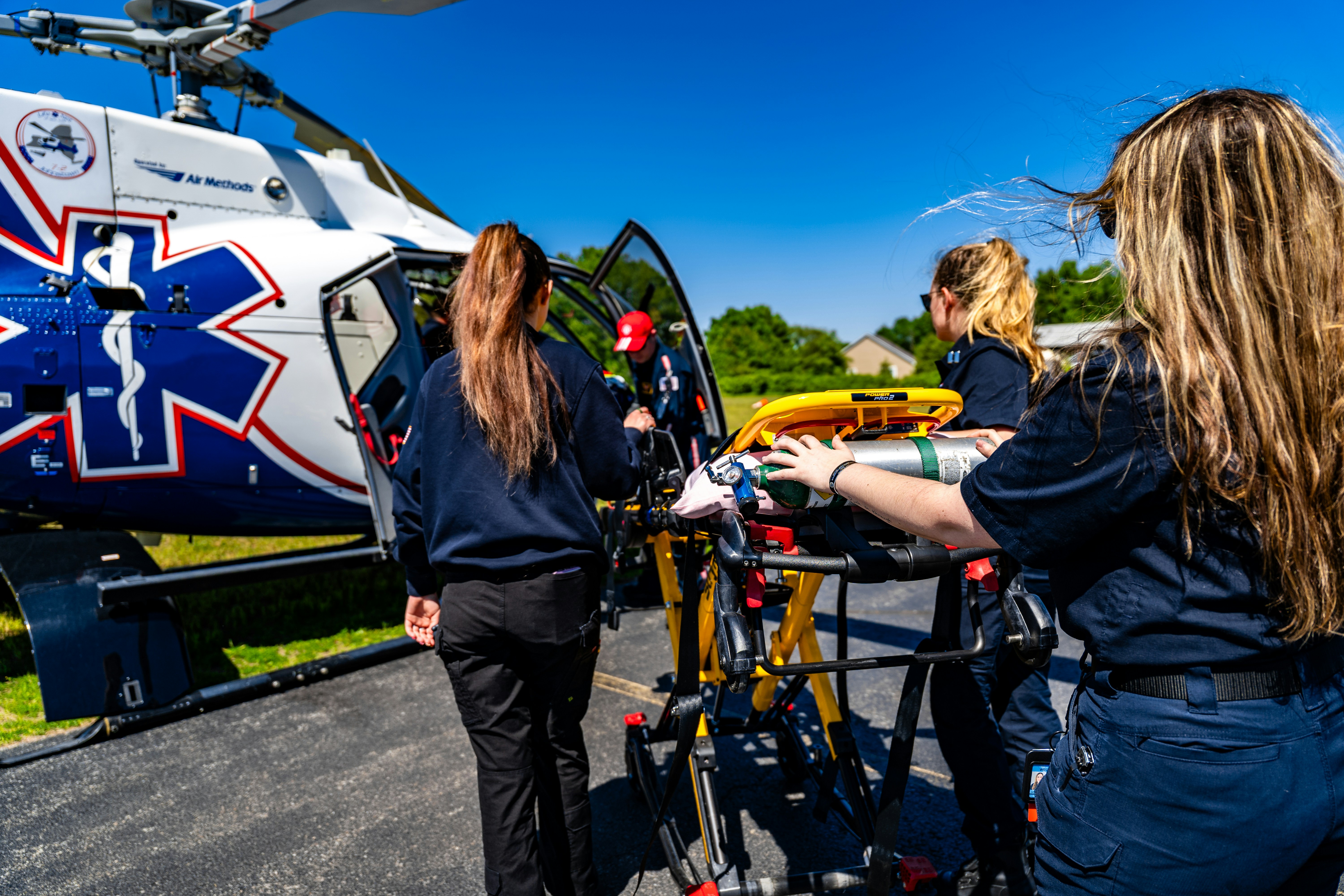 First Responders Prep: Ground Team Aligns on a Patient Stretcher beside a Rescue Helicopter