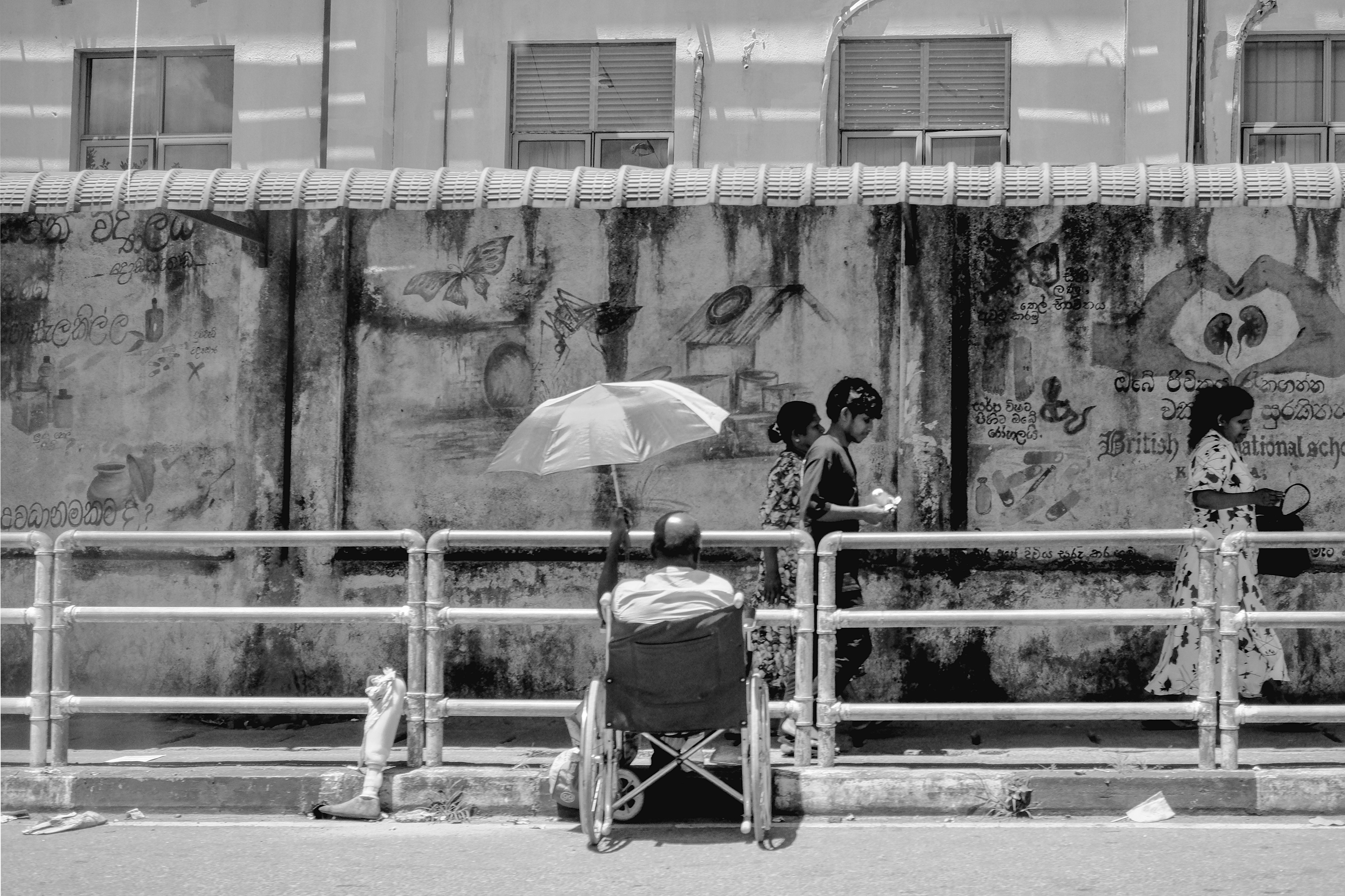 Umbrella Seekers: Quiet Moment on a Graffiti-Walled Avenue