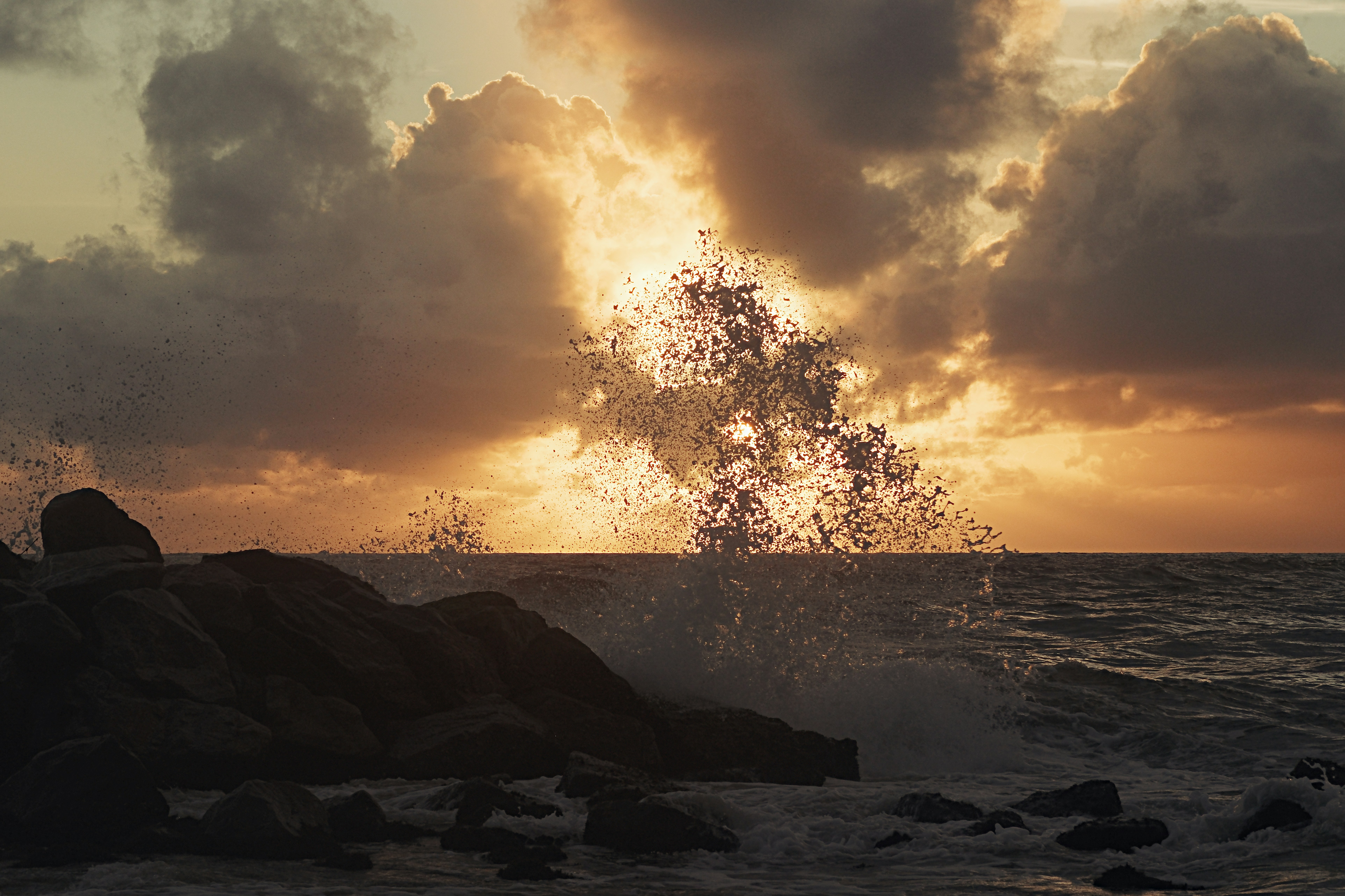Rogue Crest at Sunset: A Wave Breaks Over the Rocks