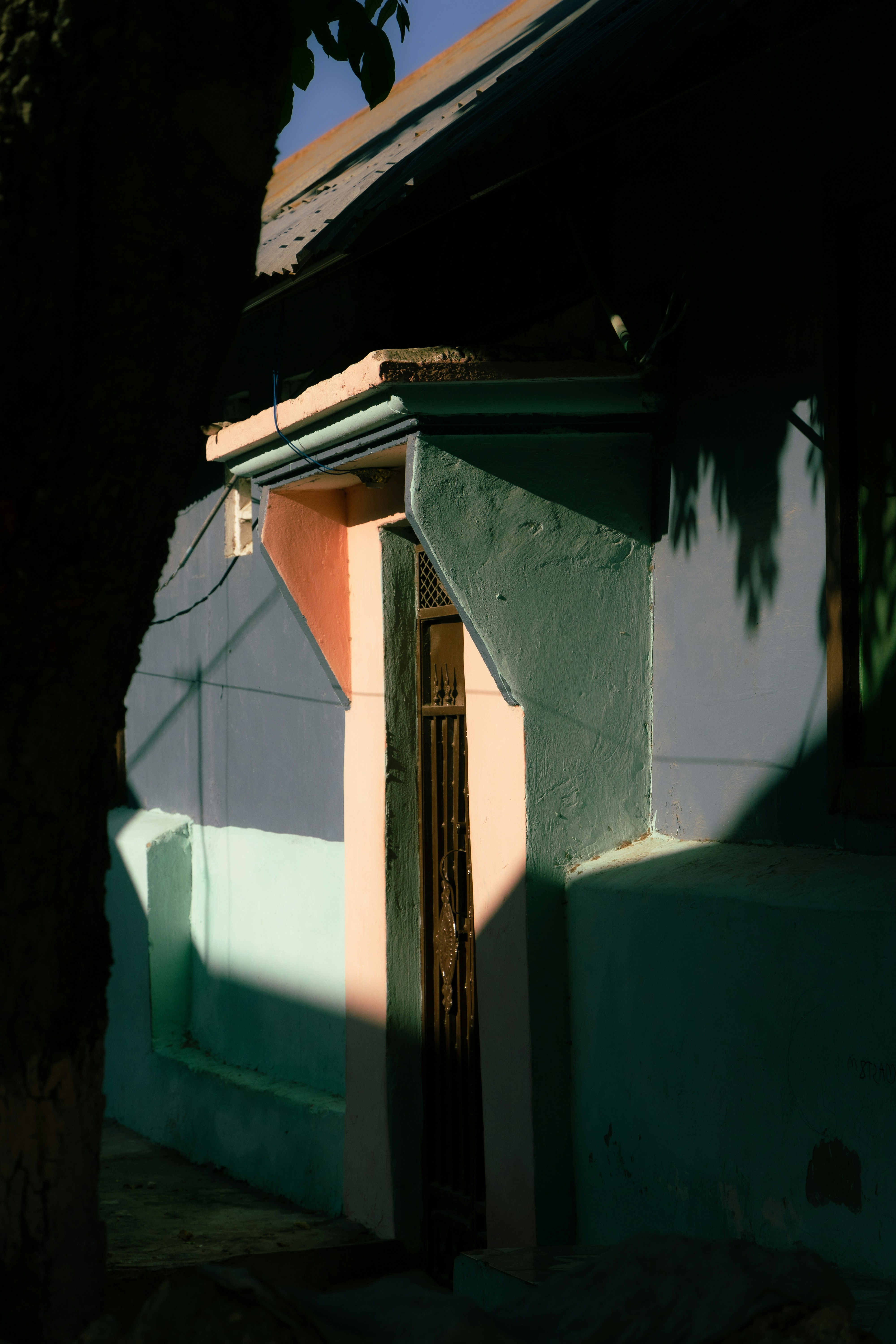 Sunlit doorway tucked by a shadowed wall