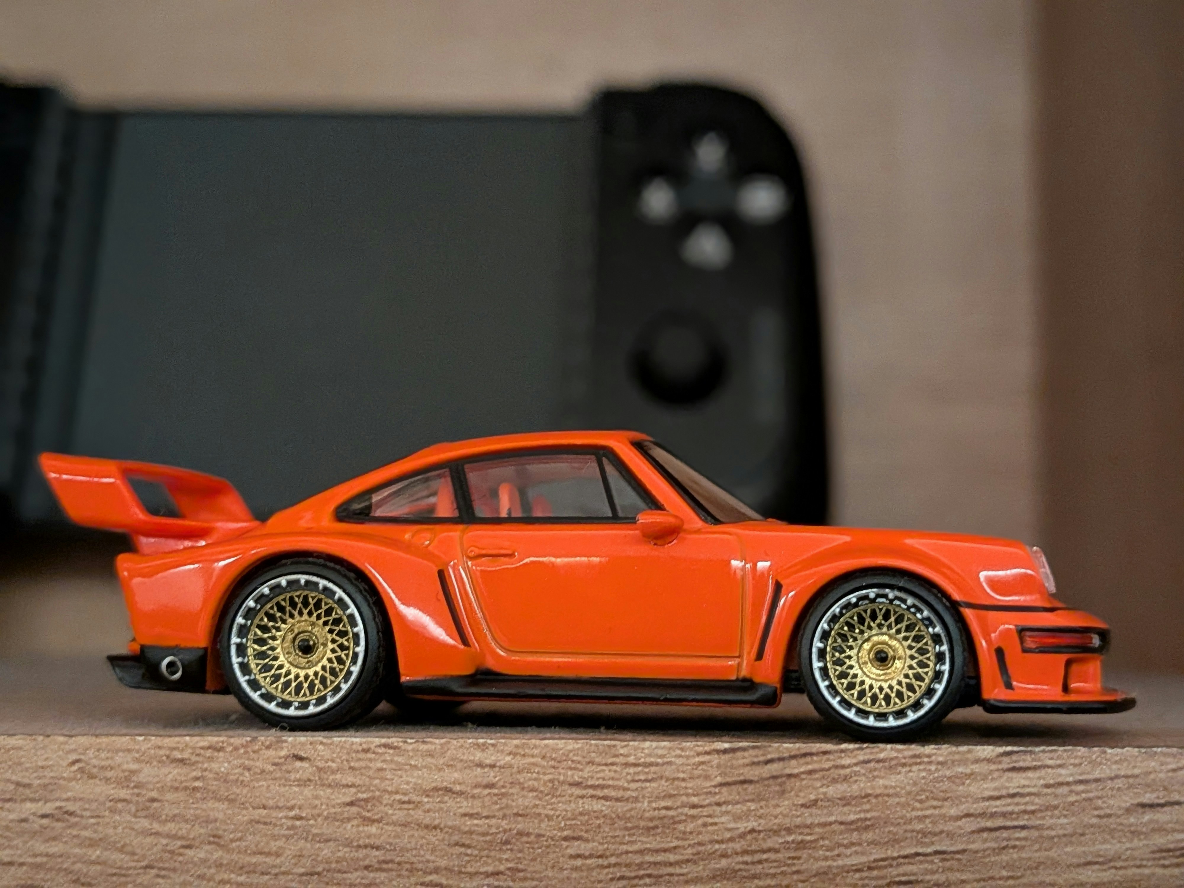 Orange toy Porsche undersoft light with blurred background
