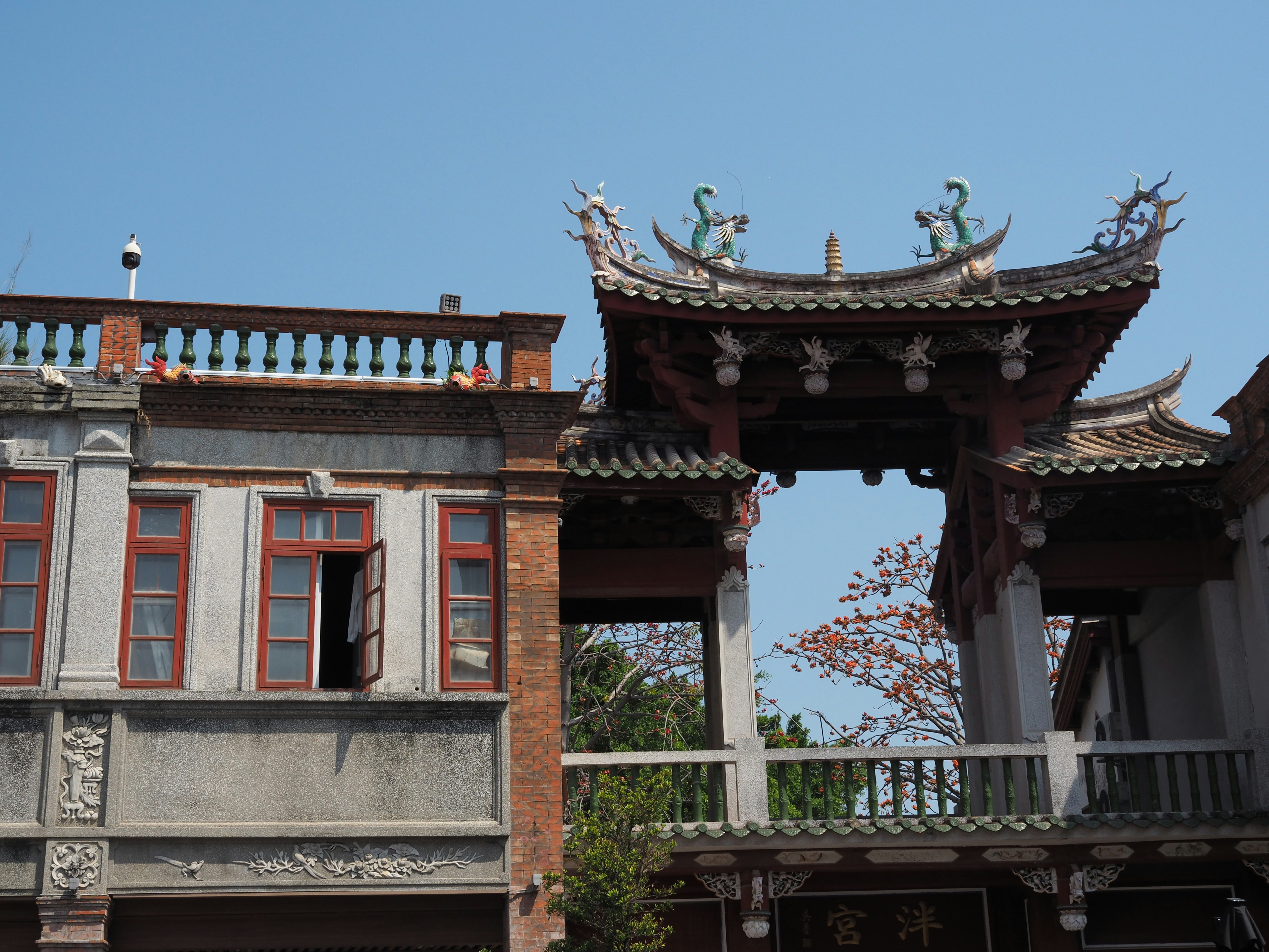 Architectural Crossing: A Traditional Gate Framing the Modern Facade