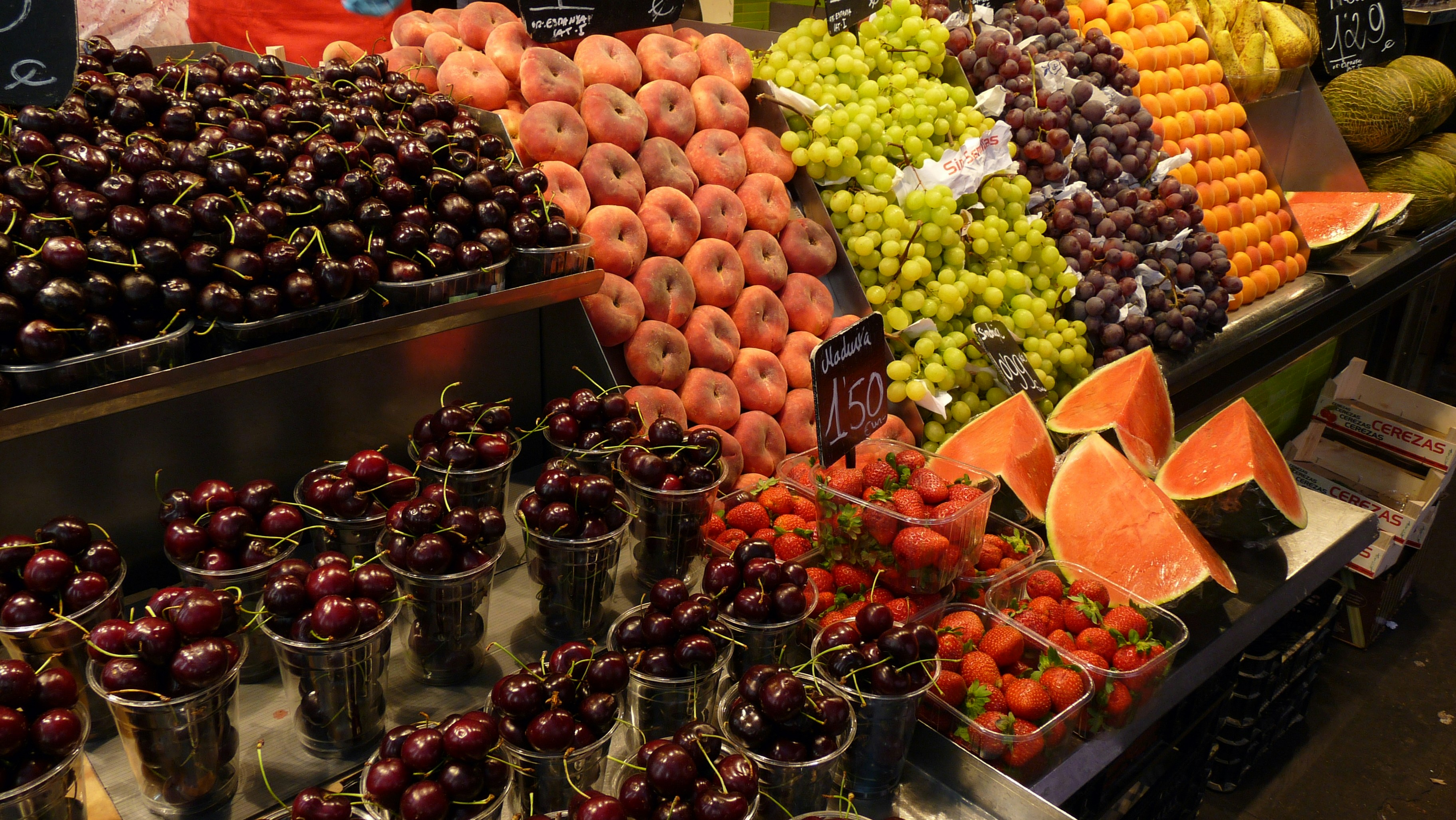 Vibrant Fruit Market Display with Cherries, Peaches, Grapes and Watermelon Slices