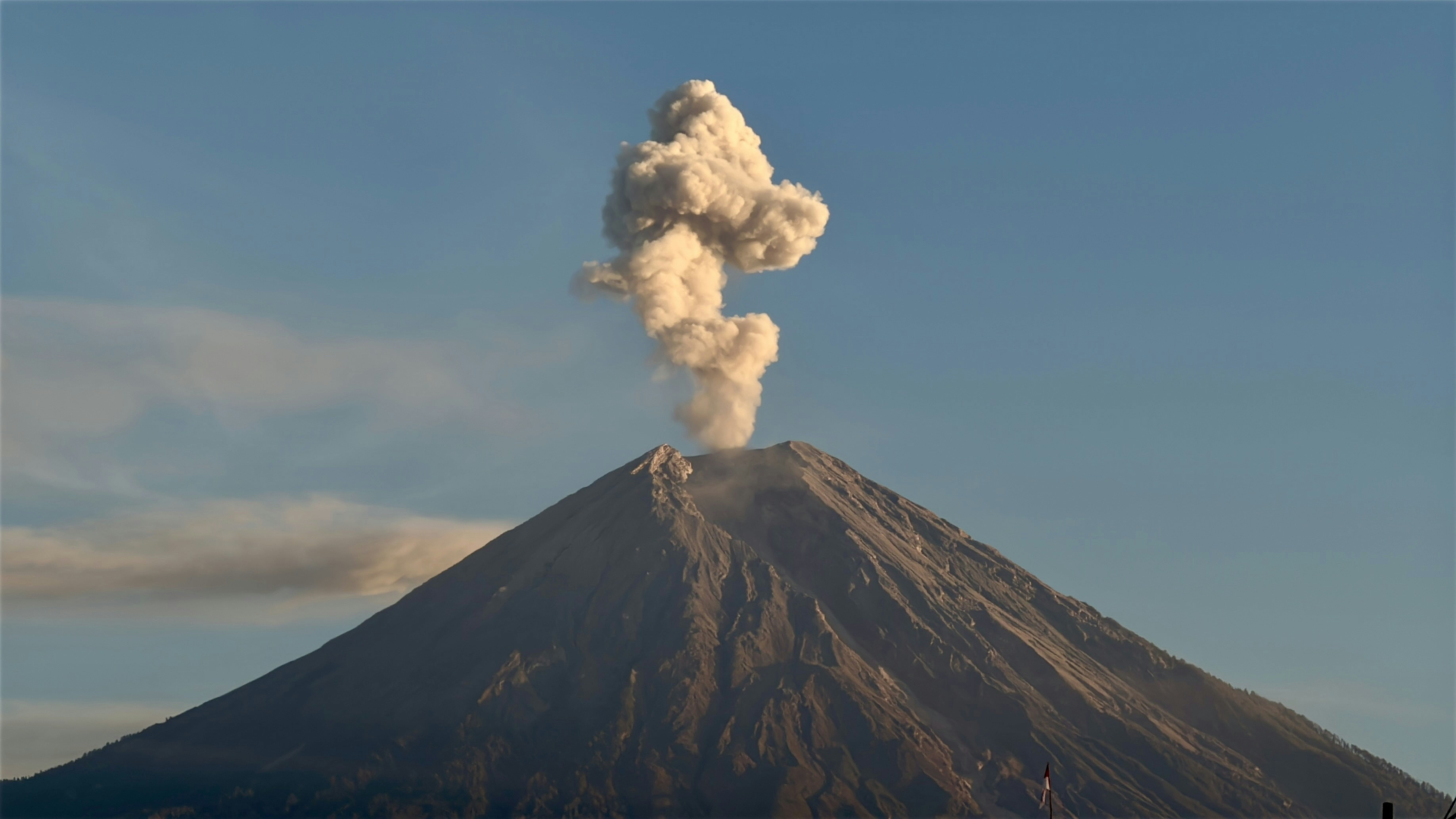 Emergence of Light from the Crater: A Molten Summit Above the Quiet Coast