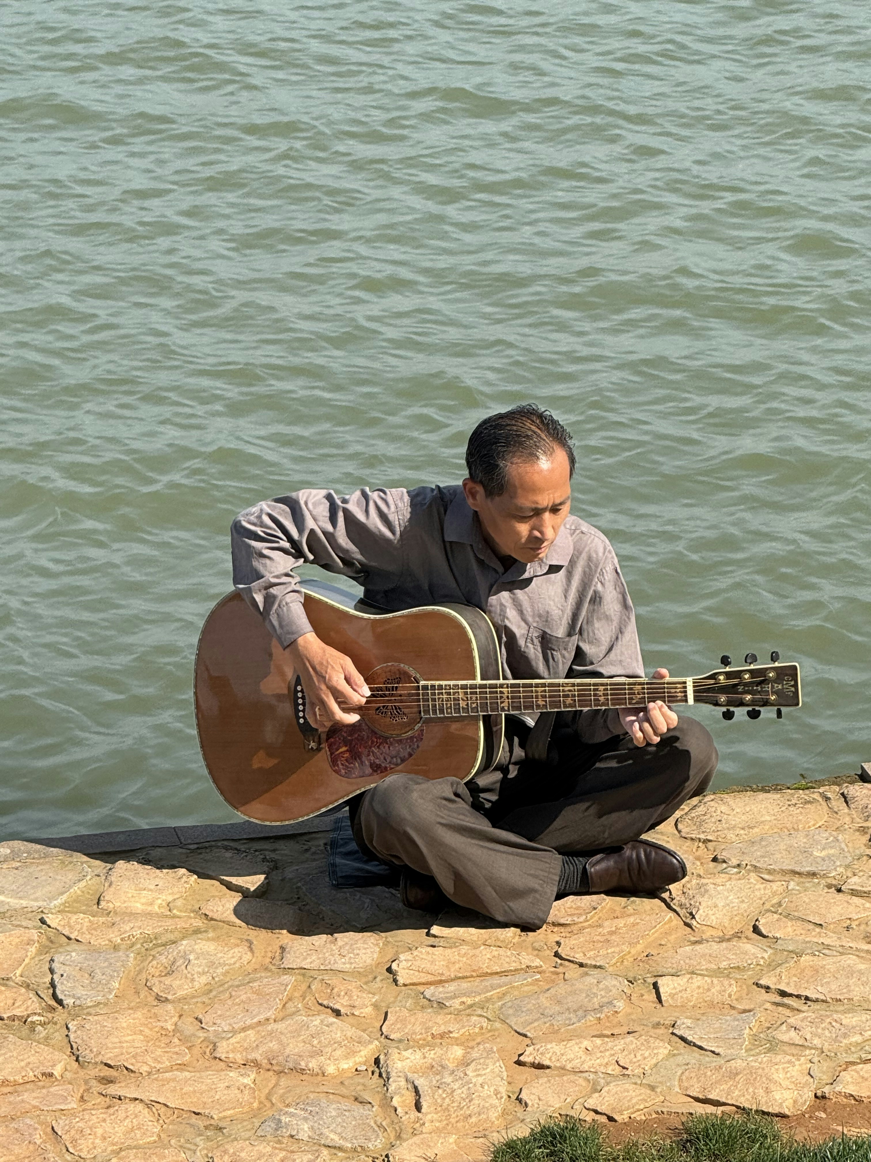 Guitarist by the Lake: Solitude on Stone