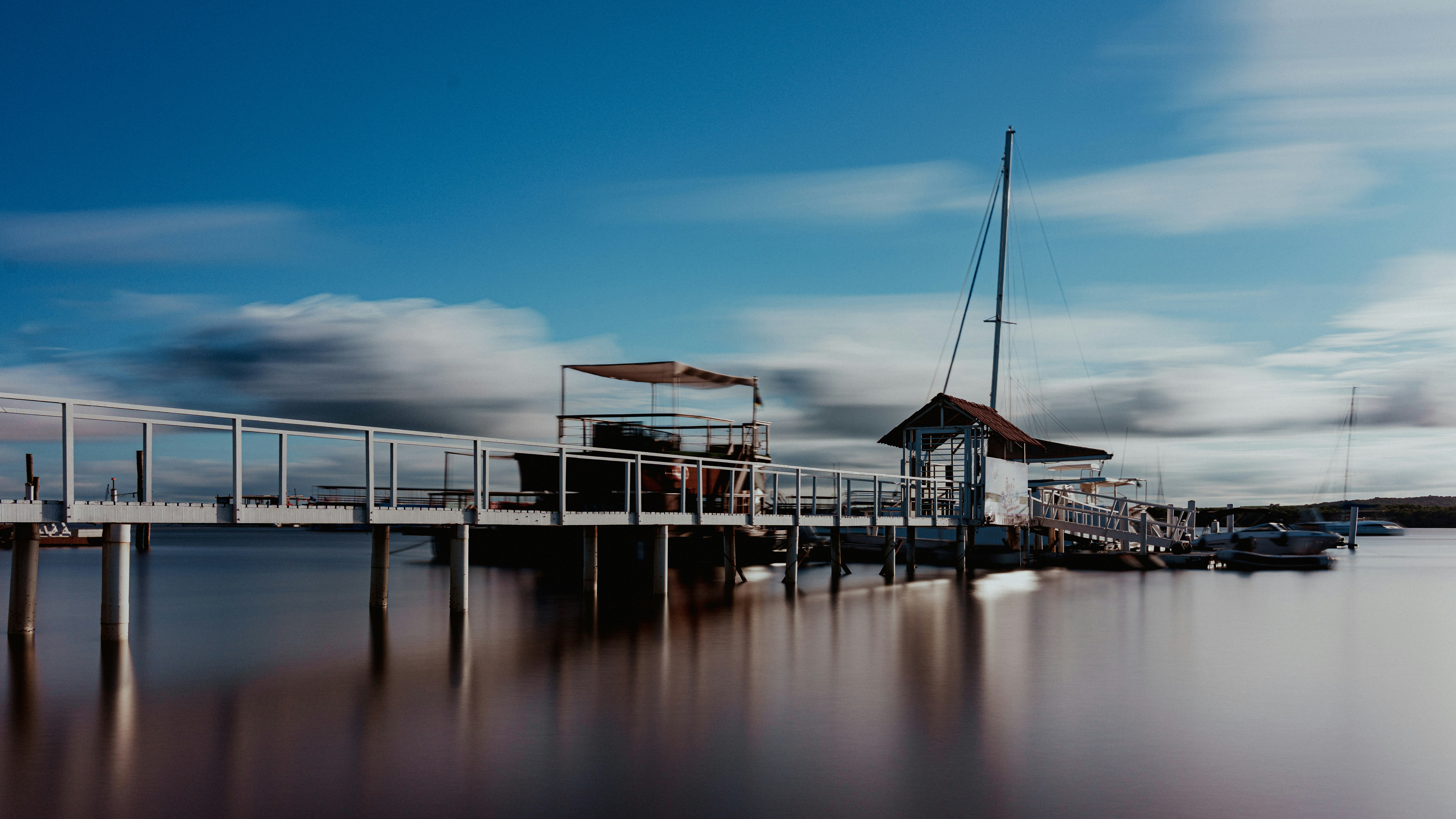Serene Marina: A Long-Exposure Dance of Clouds and Boats