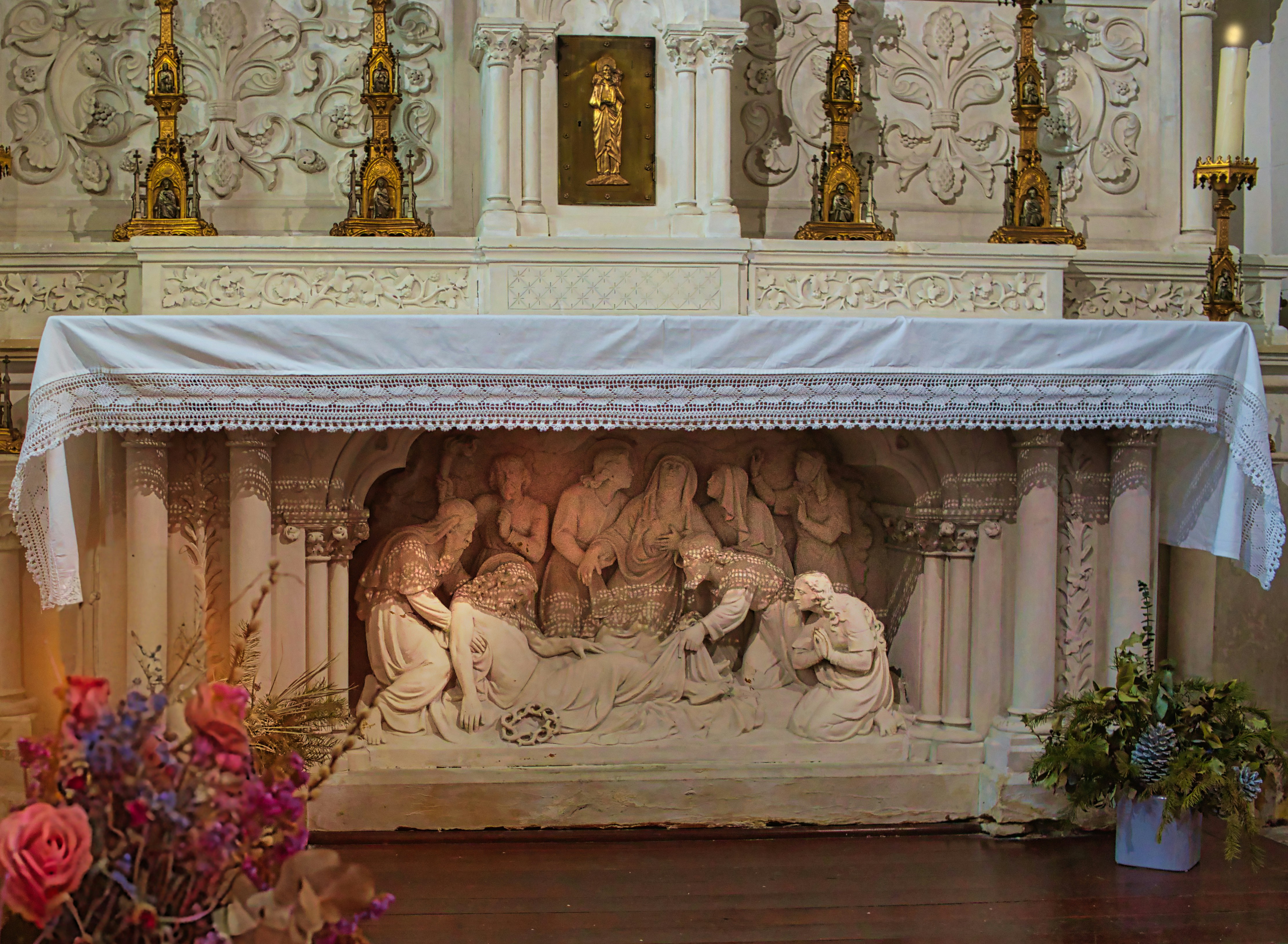 Ornate Altar Relief: A Quiet Congregation under White Drapery
