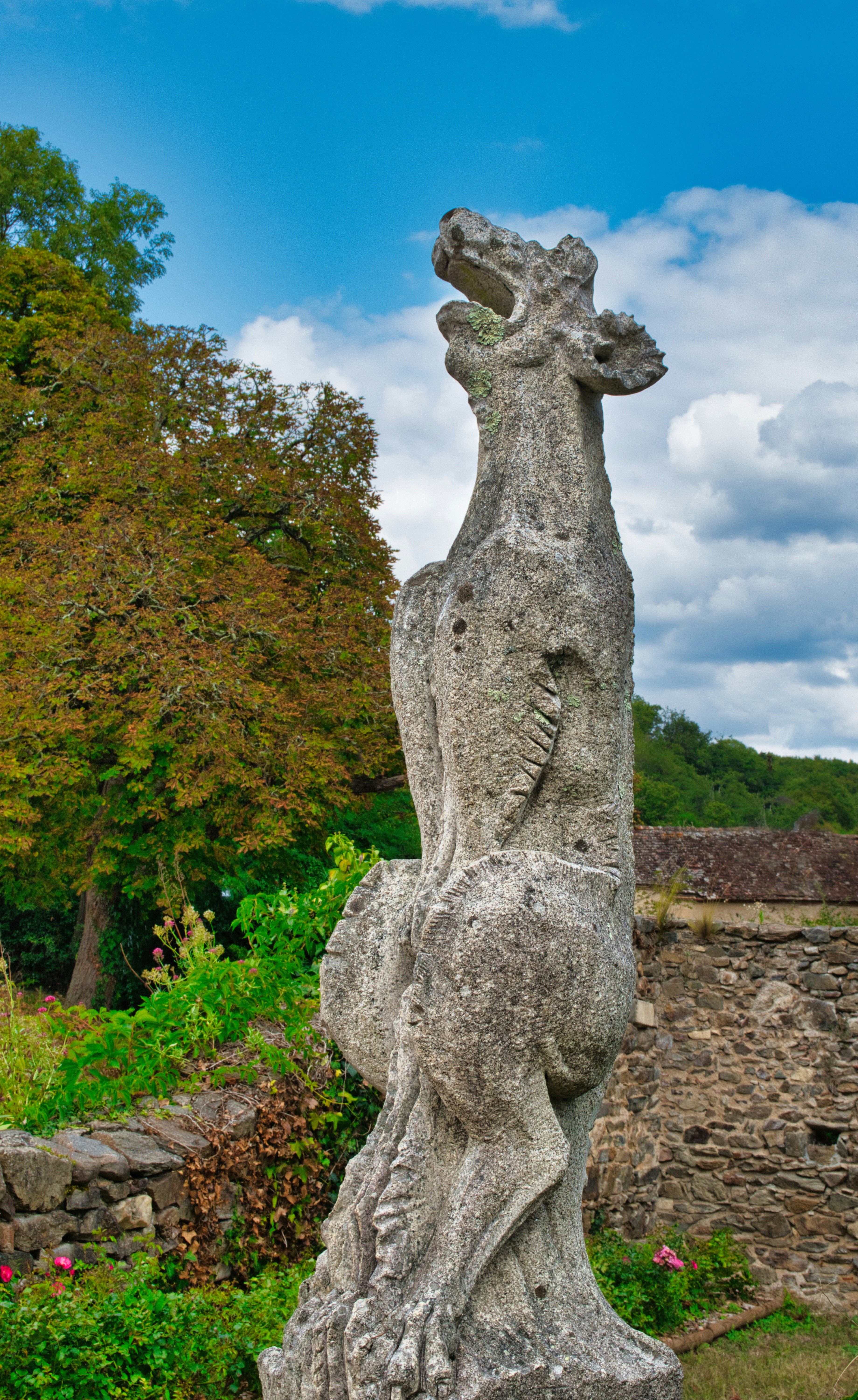 Stone Sentinel: A Weathered Gargoyle Reaching Toward the Sky