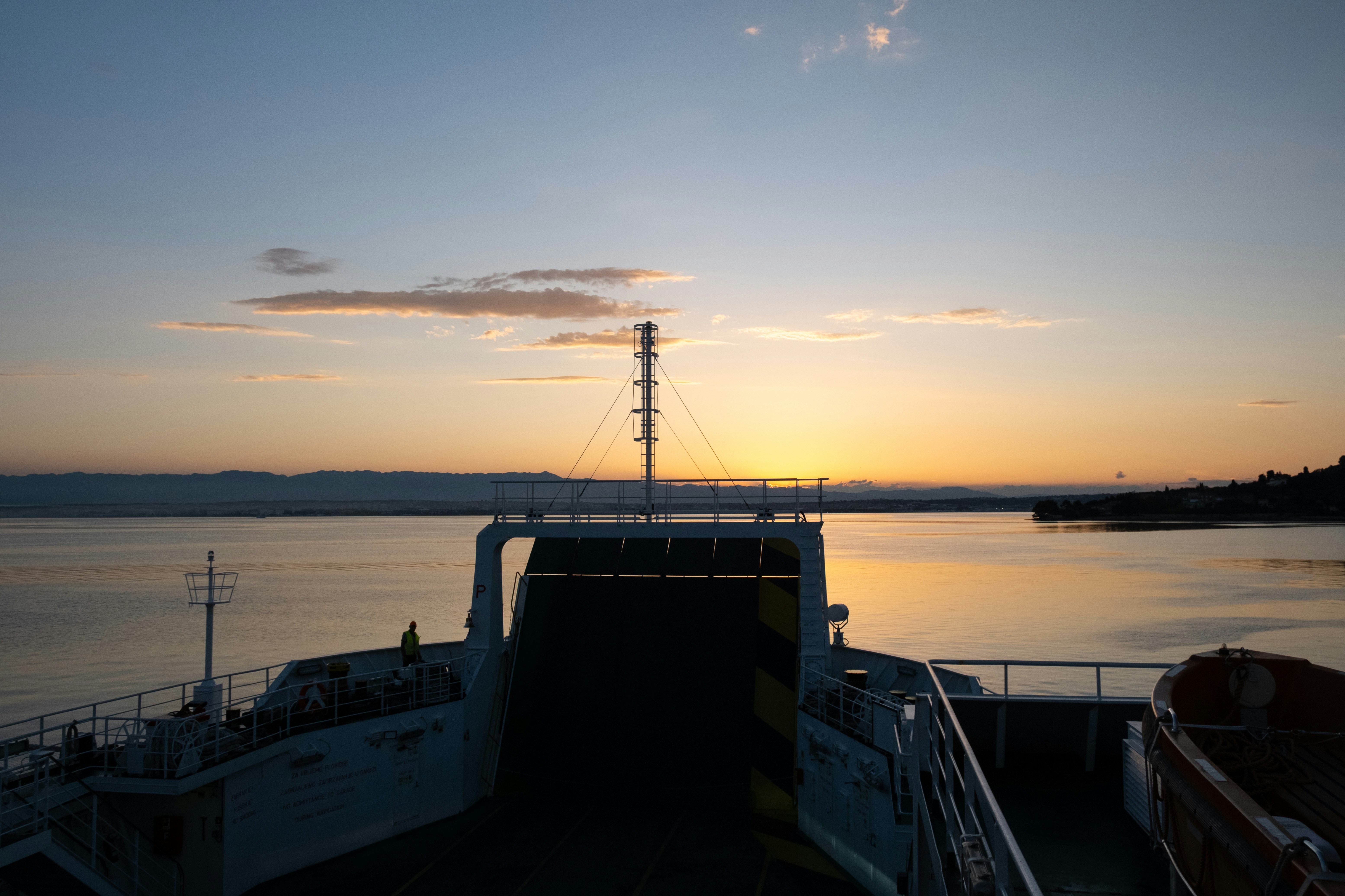 Sunset Ferry Terminal: silhouette of a docked boat at calm harbor