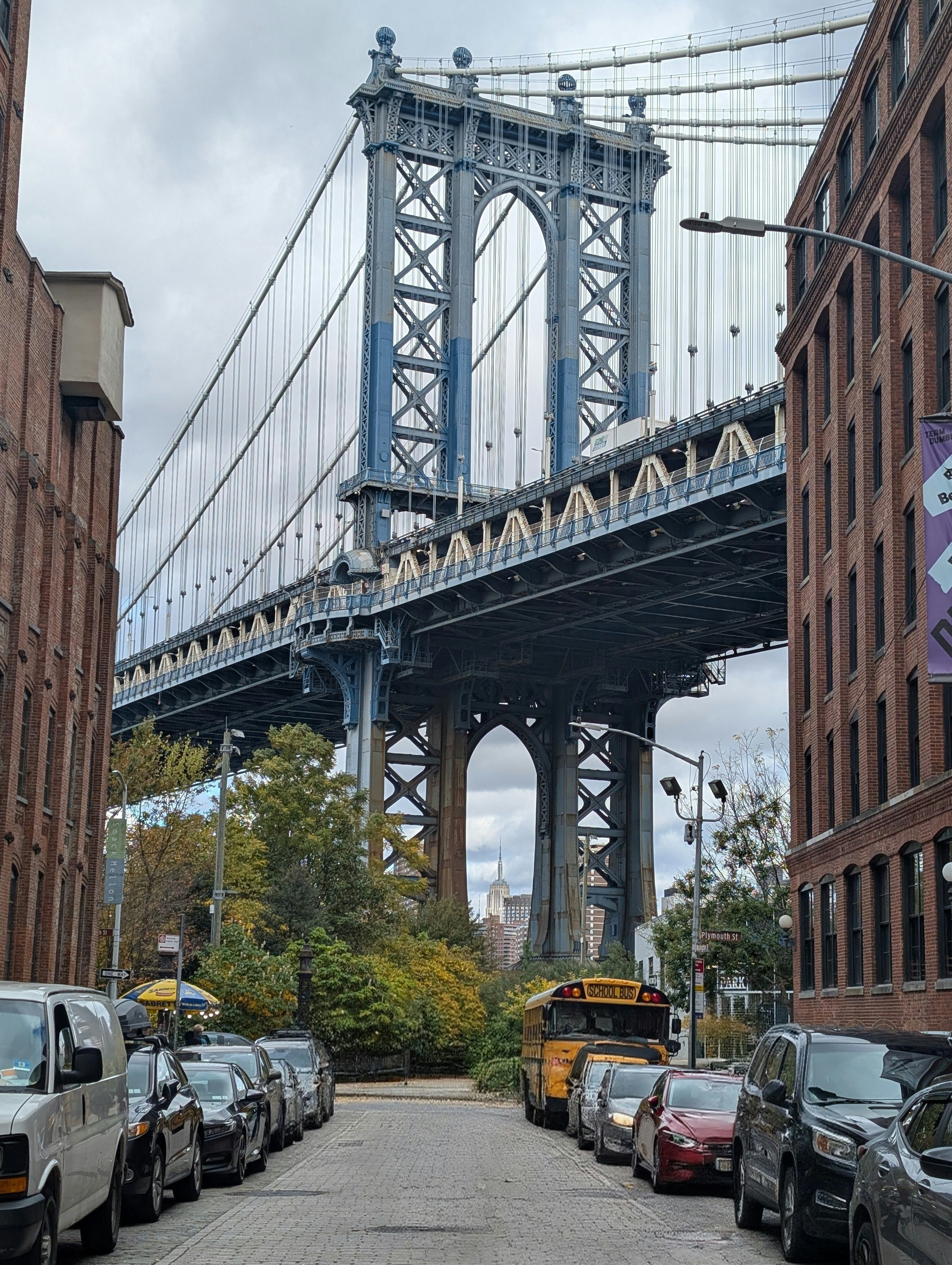 Manhattan bridge framed by buildings on a city street.