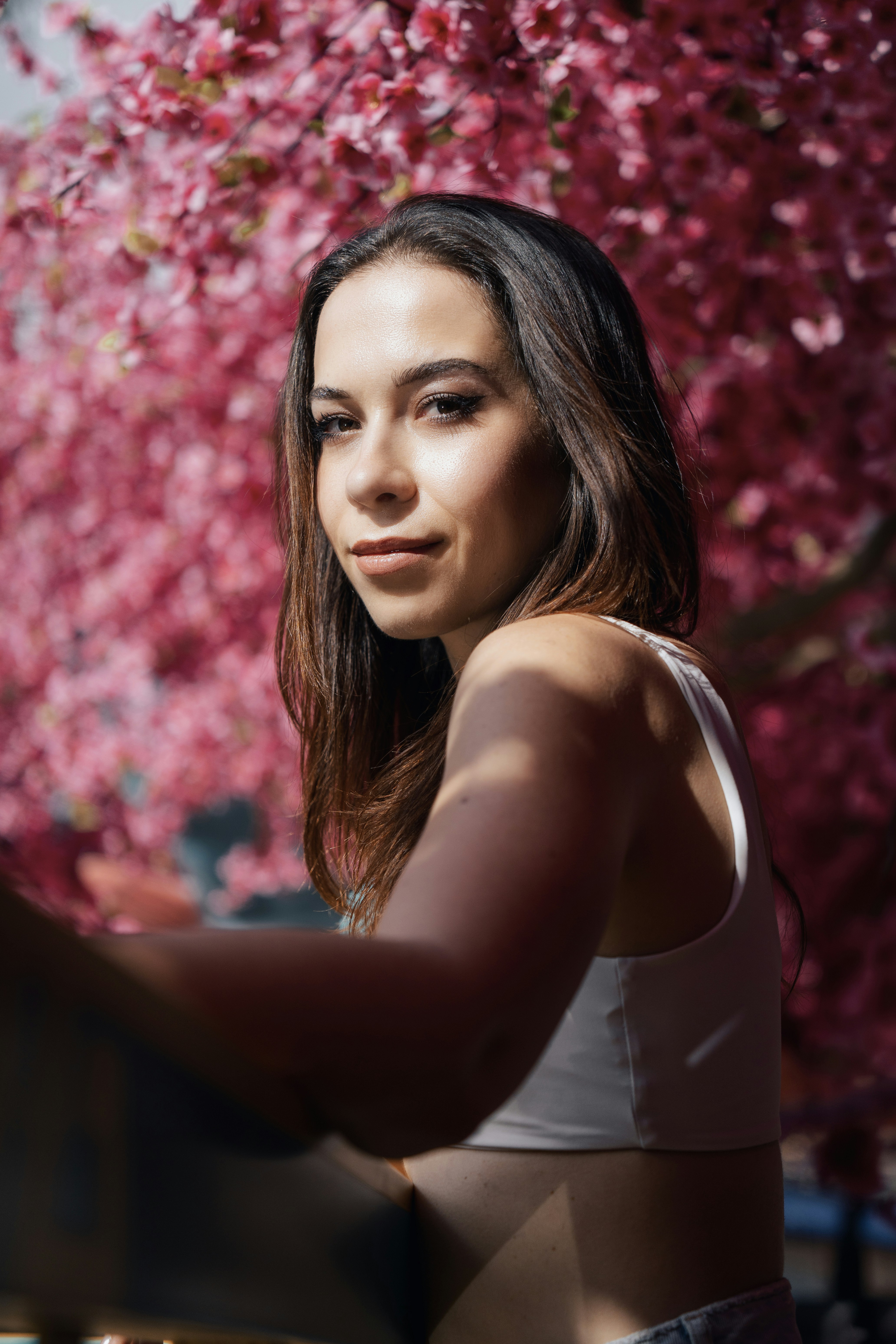 Blossoms and gaze: a portrait framed by pink clouds