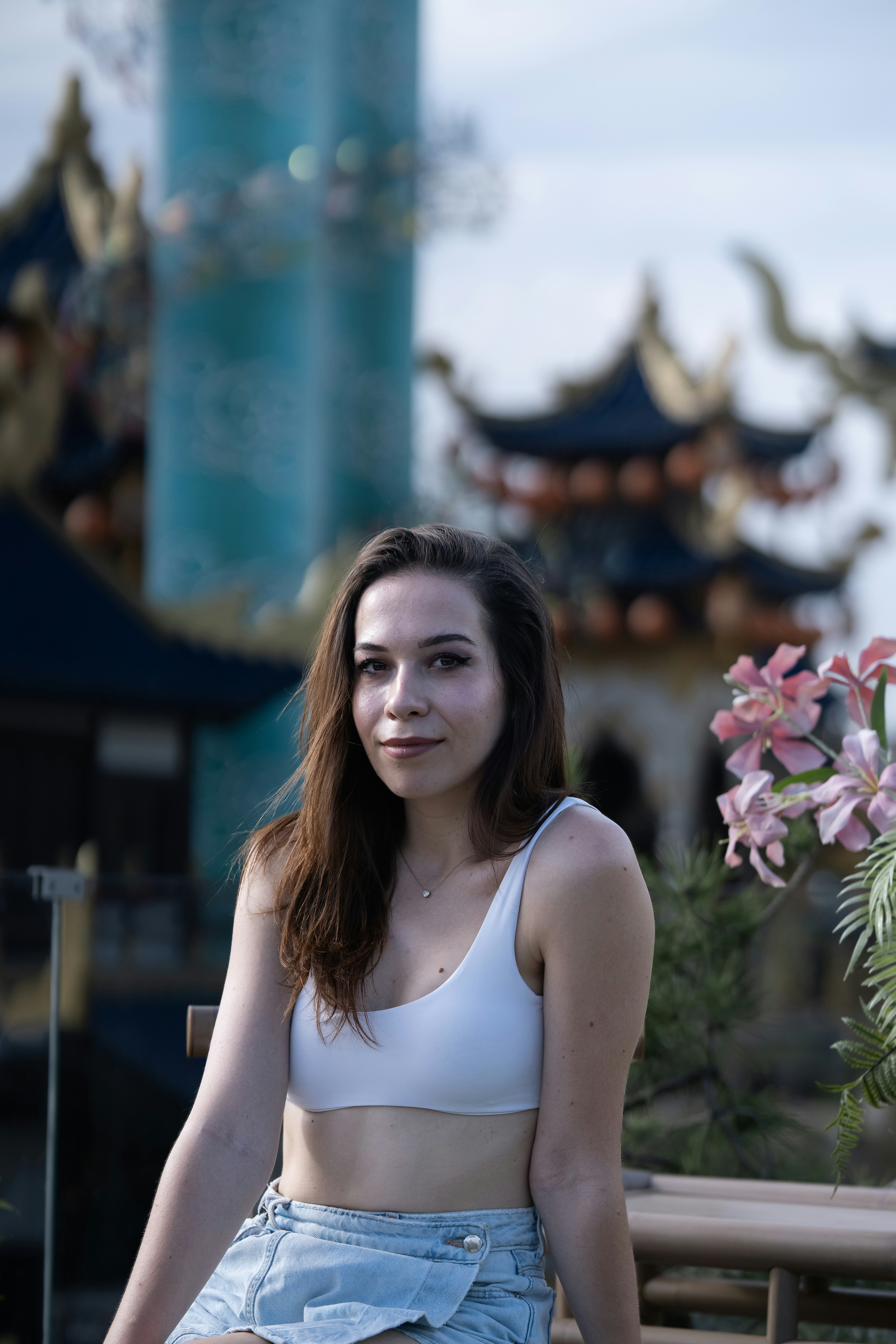 Portrait in a tranquil garden with pink blooms and temple backdrop