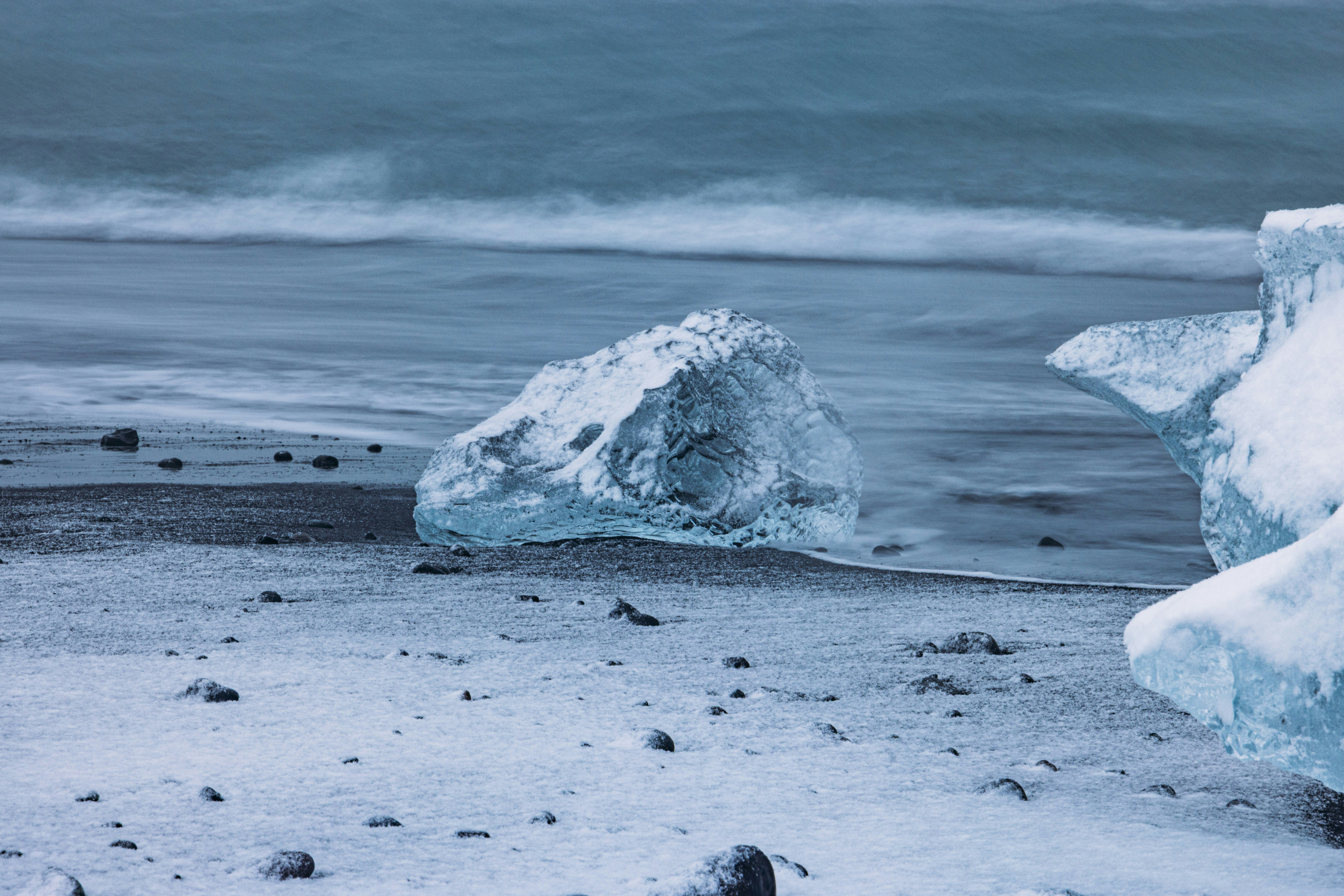 Ice Fragments Resting on a Quiet Snow-Soaked Shore