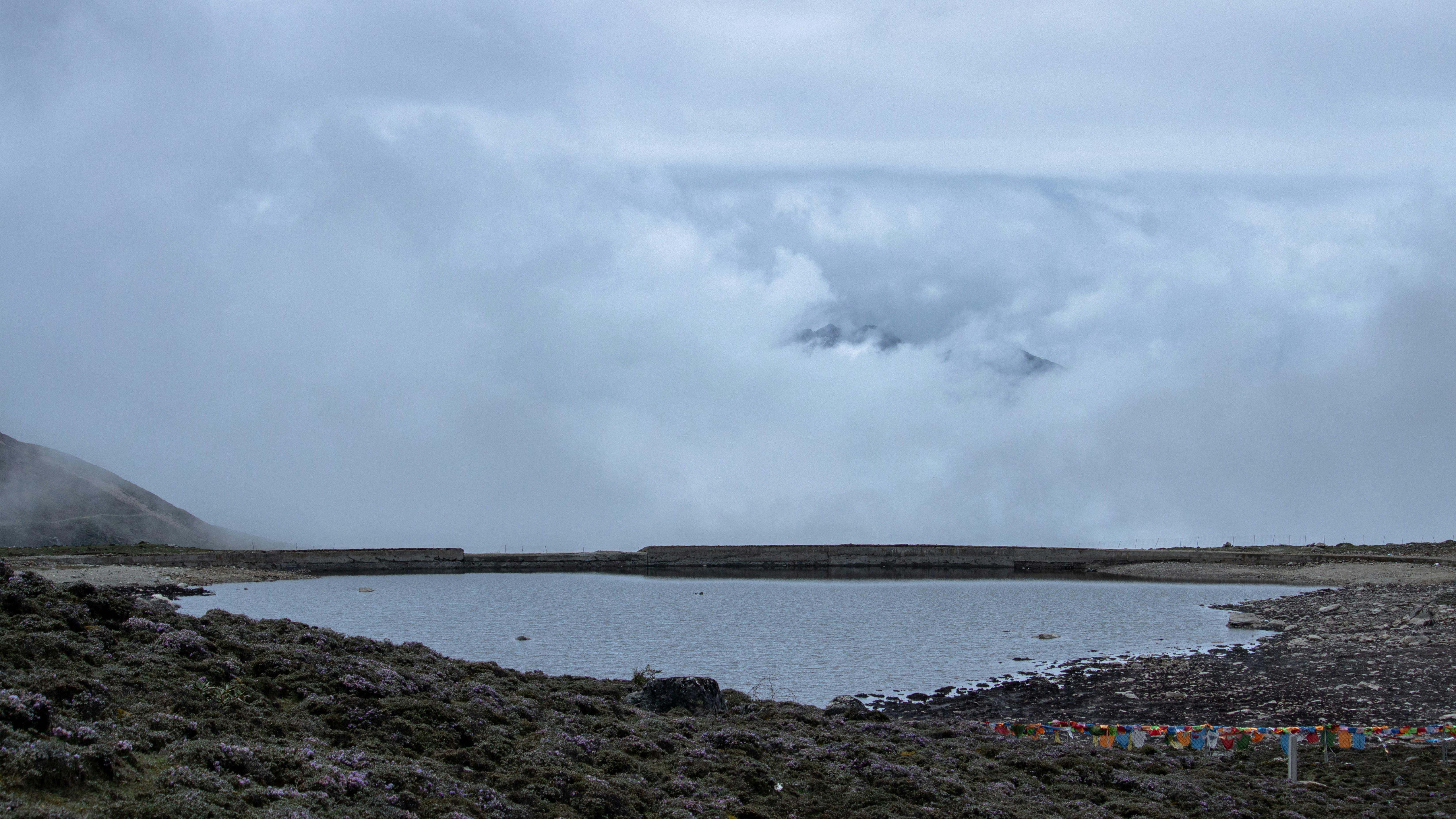 Quiet tidal pool under a brooding sky at a windswept coast