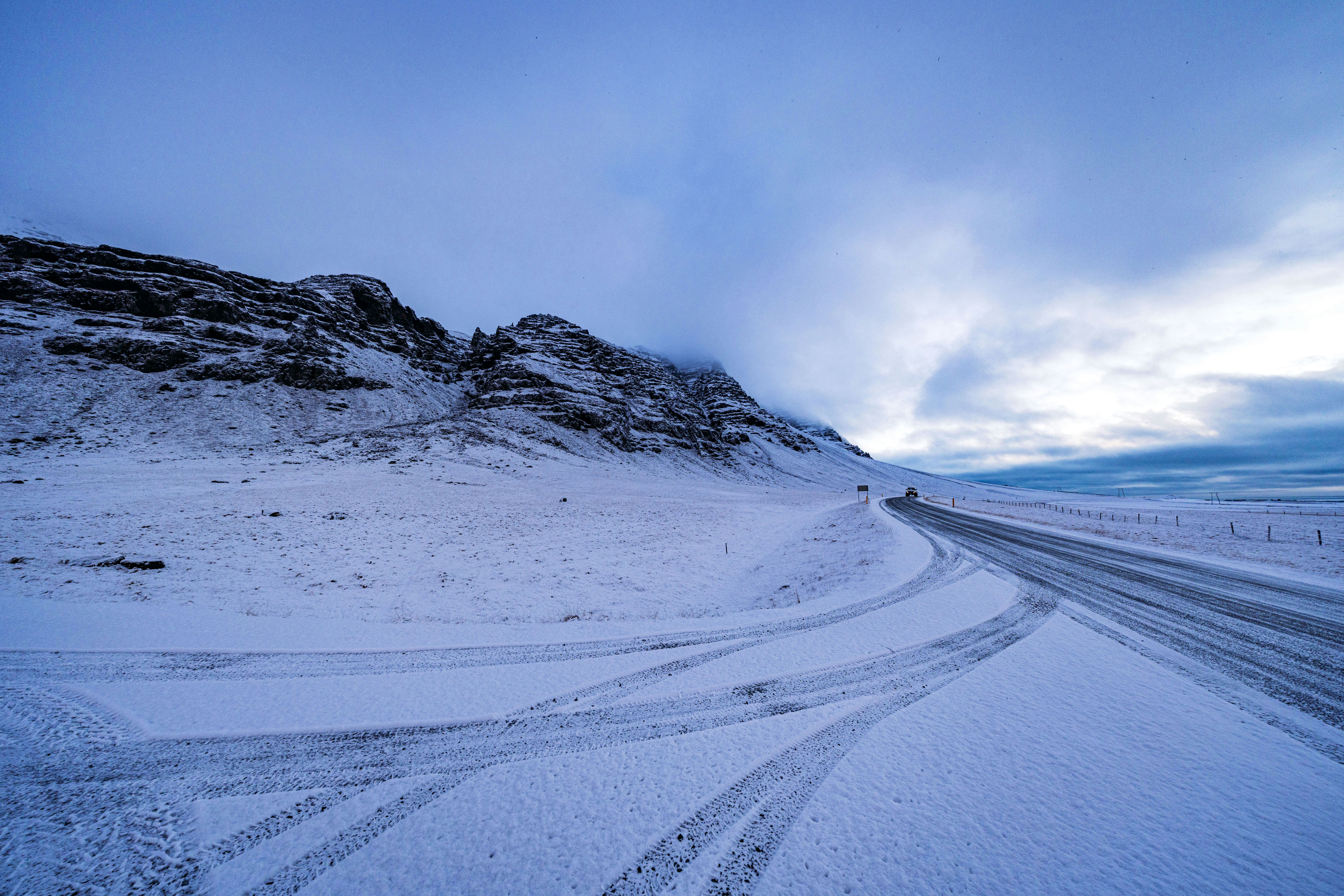Snowbound Curve: Tire Tracks Journey toward the Distant Crest