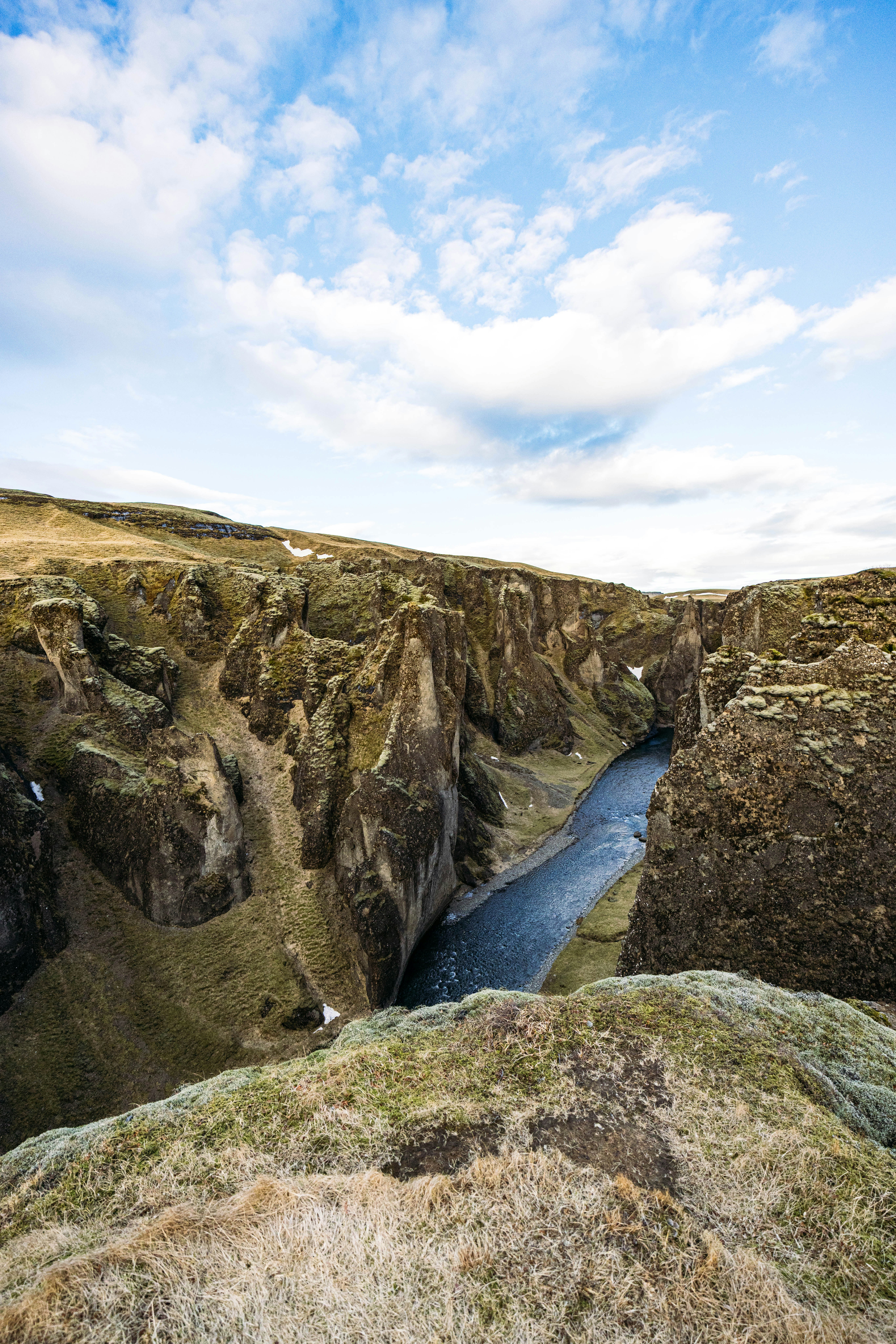 Cliff-Willed Canyon: A Narrow river through basalt cliffs under a blue sky