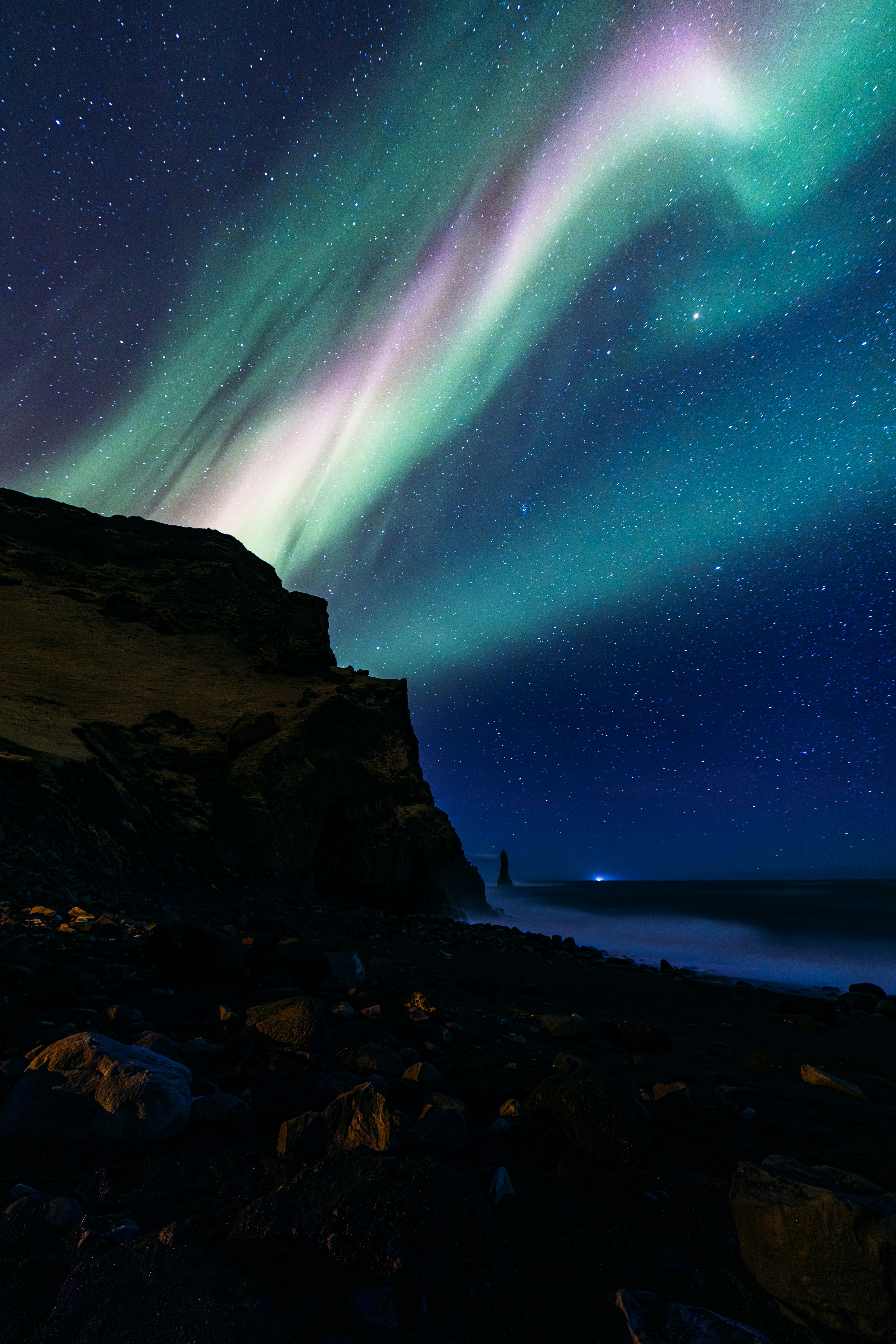 Aurora over the Coastal Cliff: Night Sky Unfolds Above the Dark Shore