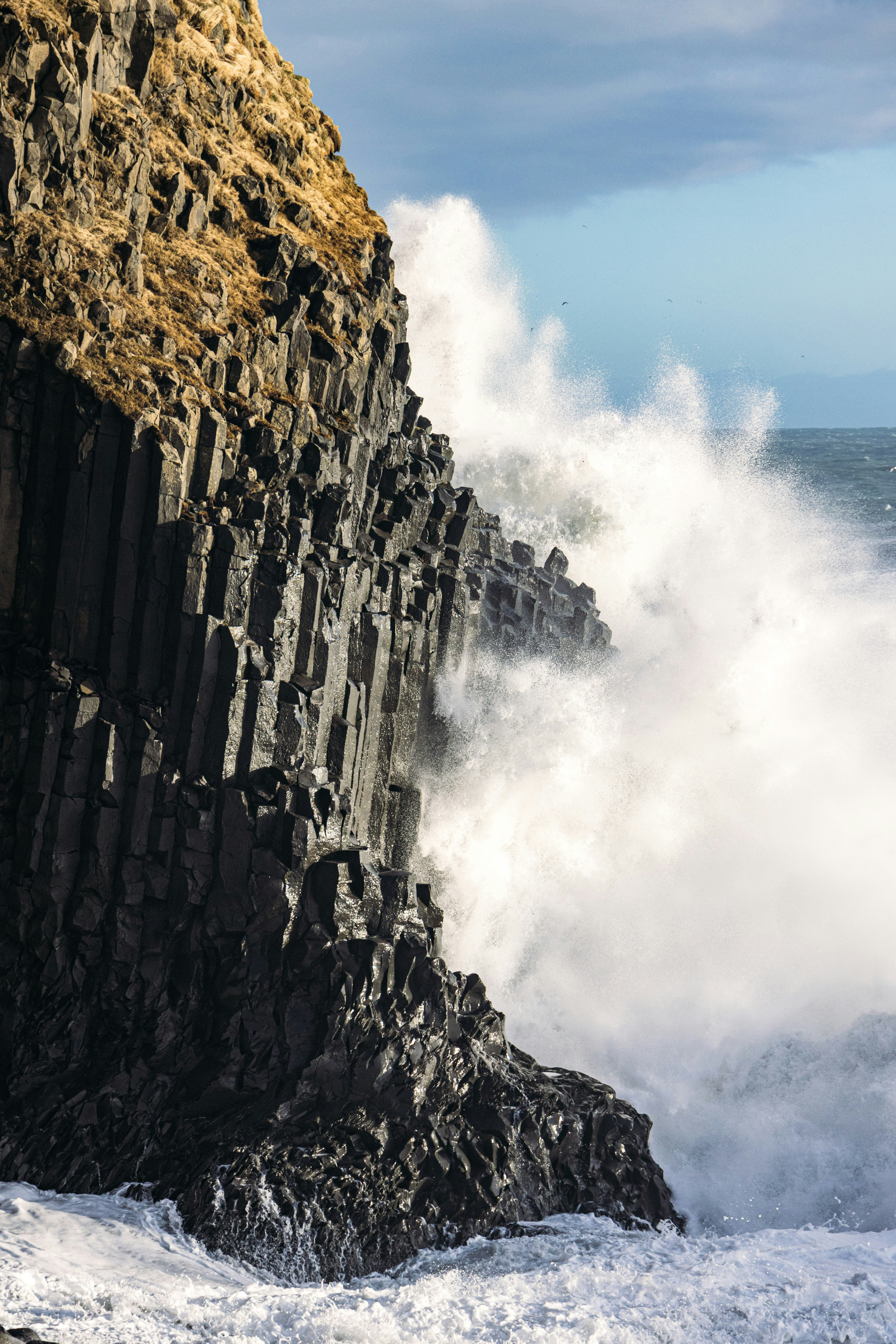 Ravenous Break: Basalt Cliffs Meet Ocean's Surge
