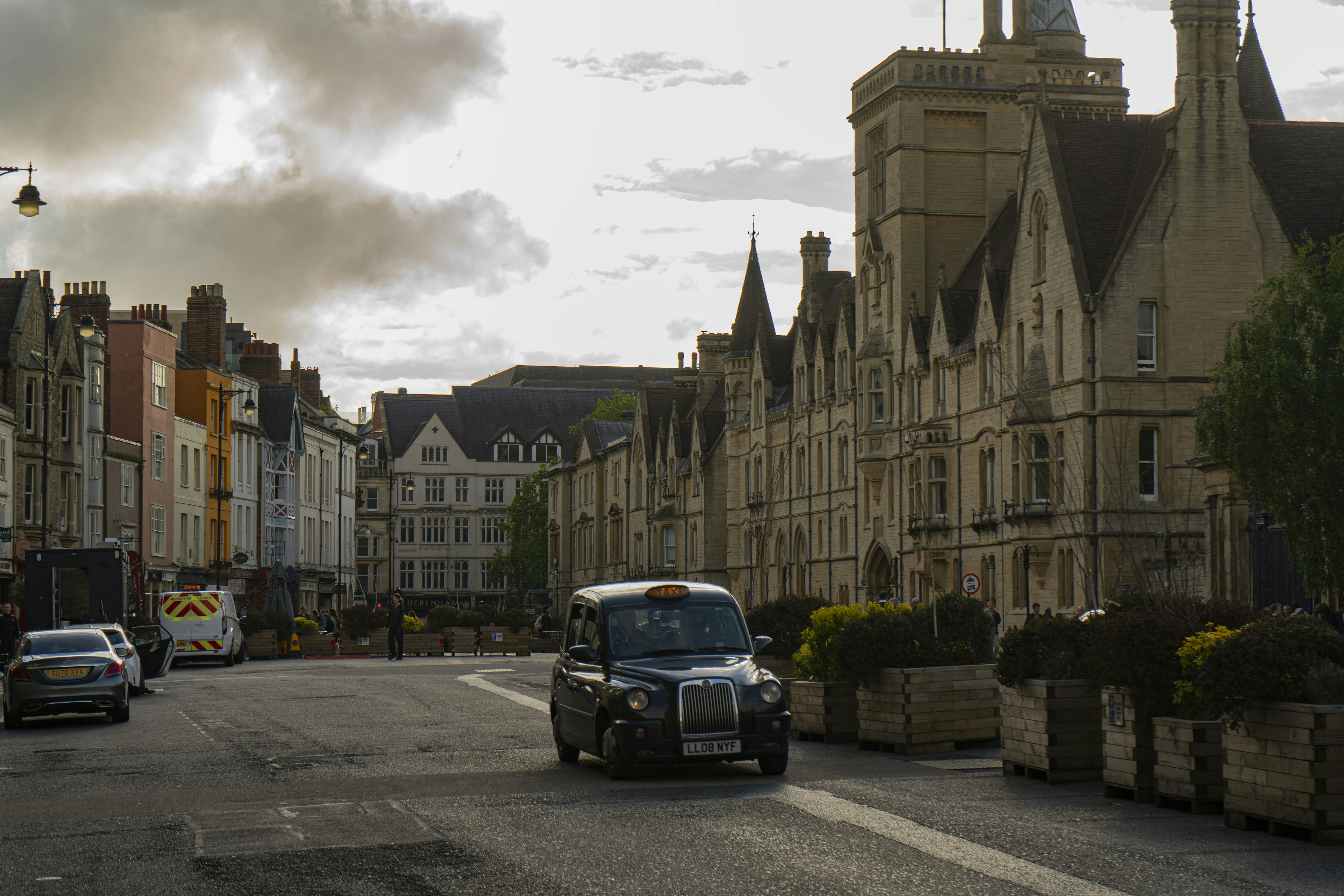 Cobbled Street Convergence: A Black Cab at the Gate of a Historic Town
