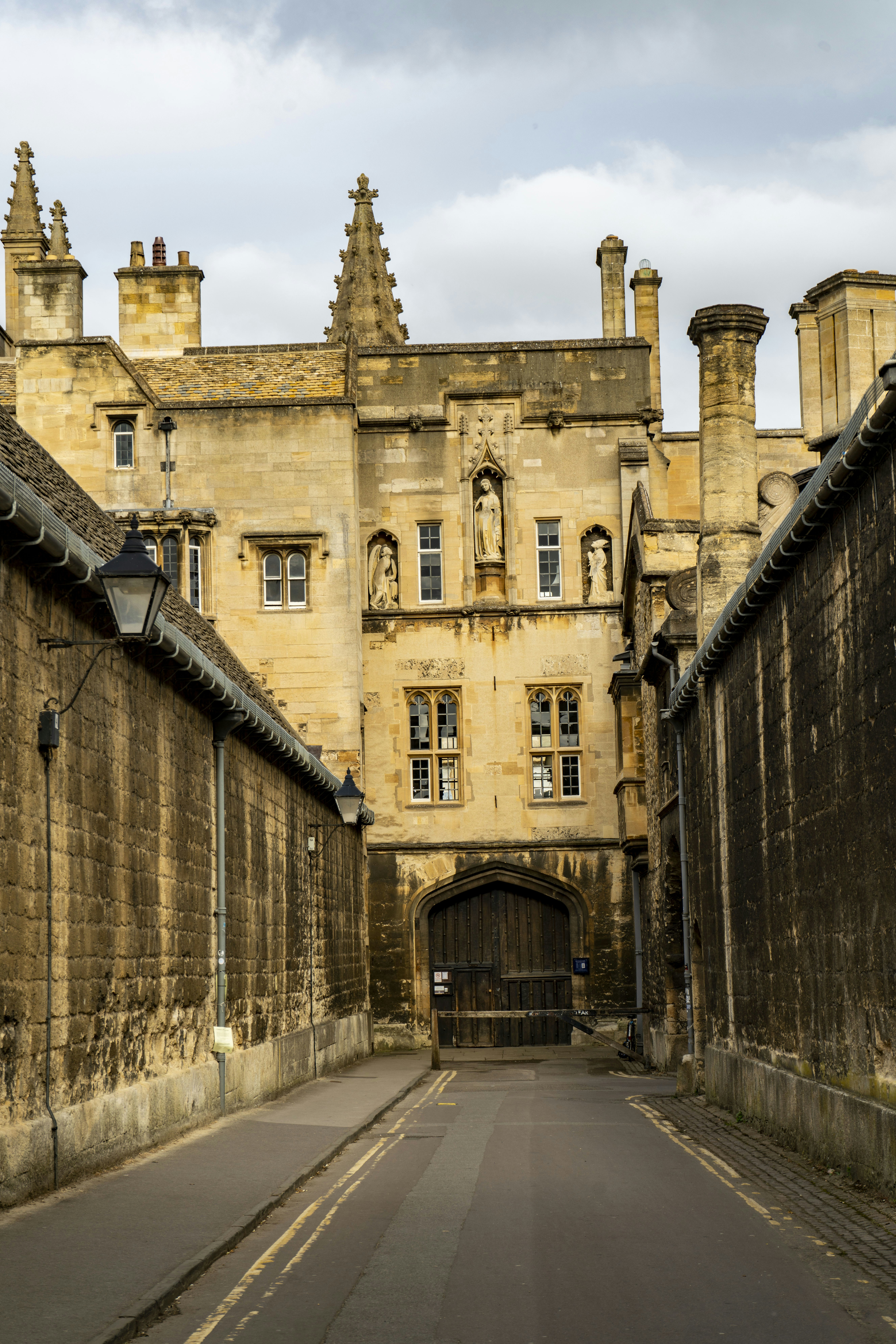 Gothic Gate: A Sunlit Courtyard Corridor Framing an Abbey Entrance