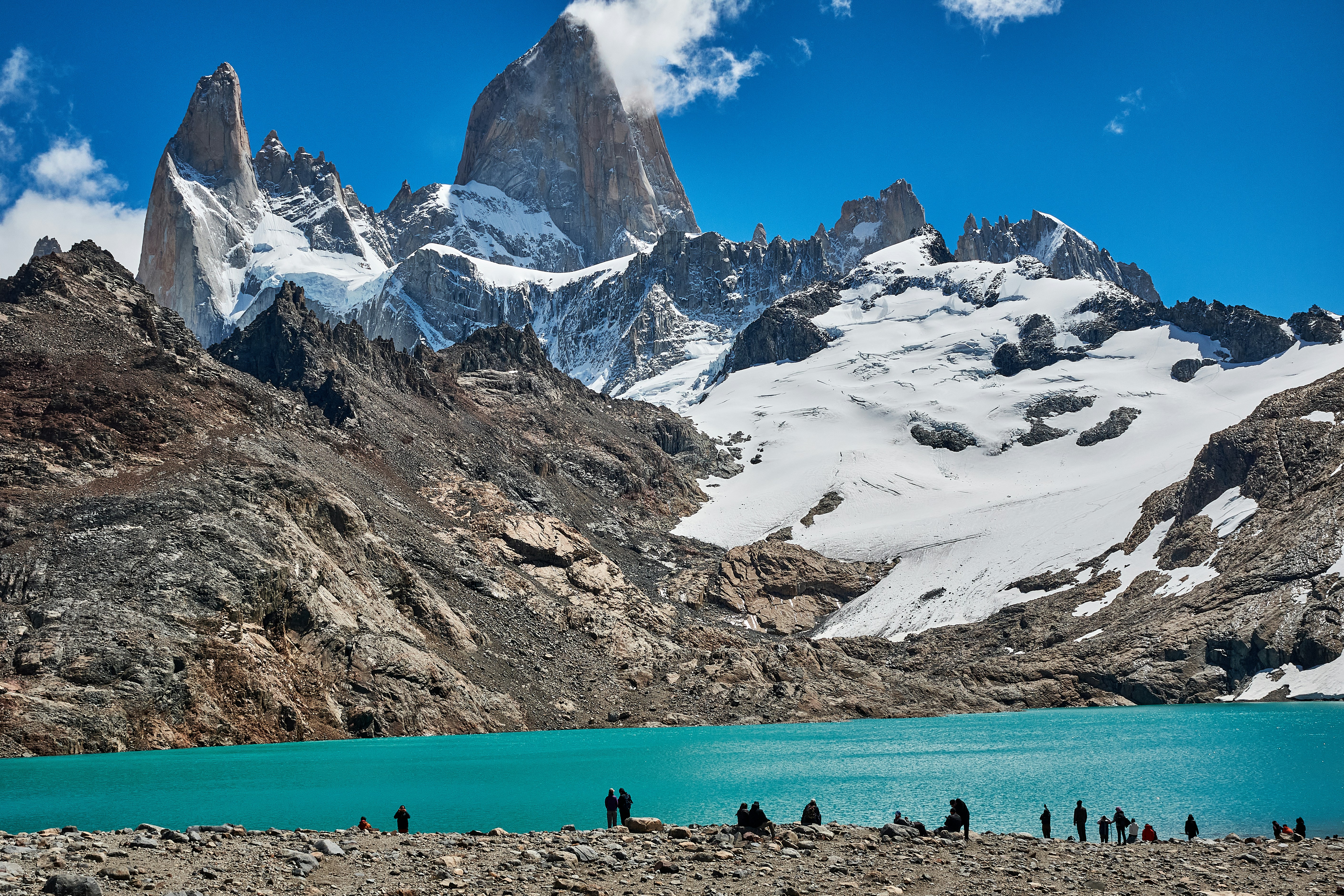 Turquoise Glacial Lake Under Jagged Snow-Crowned Peaks