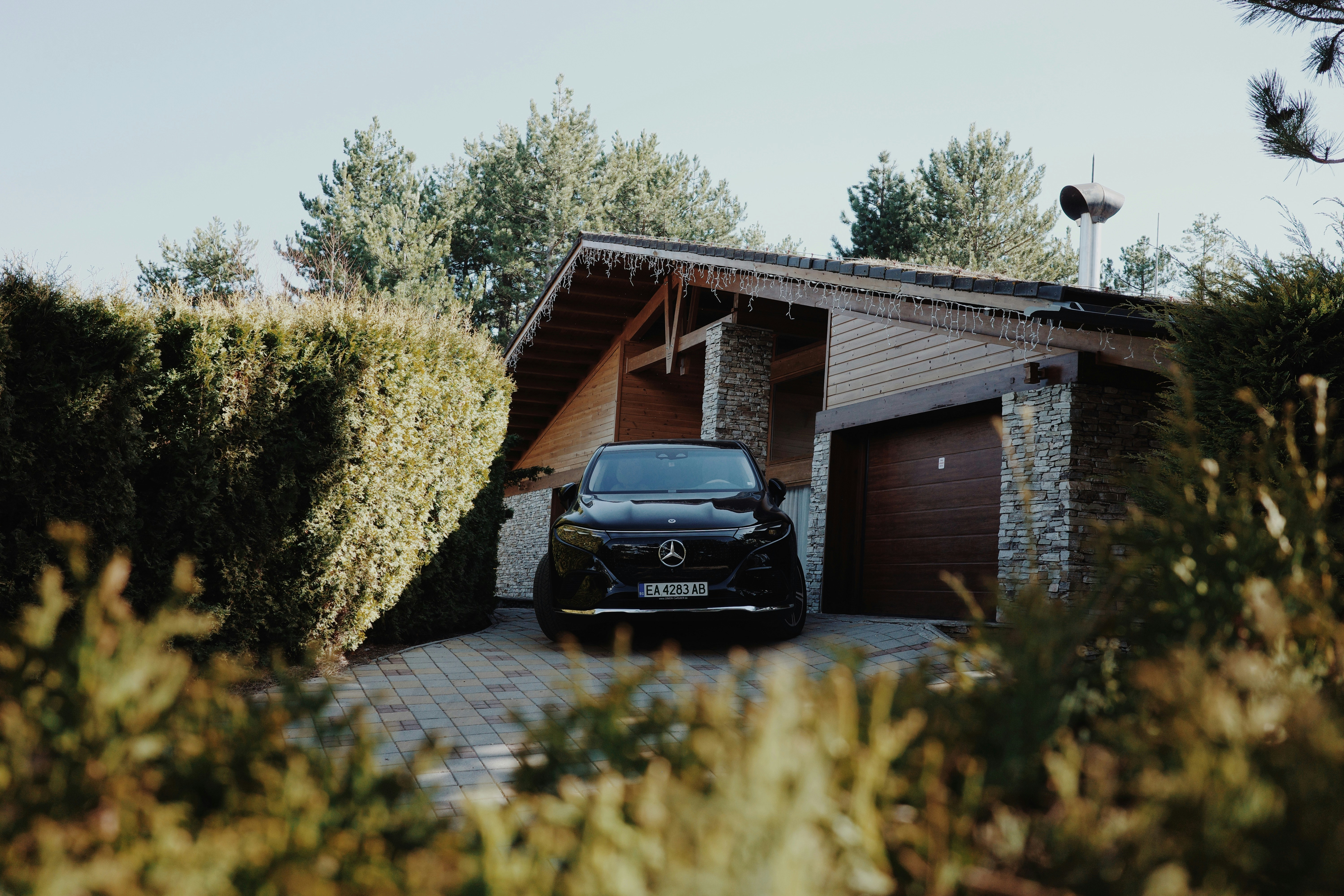 Garage Gatekeeper: A Mercedes Nestled Behind Sculpted Hedges