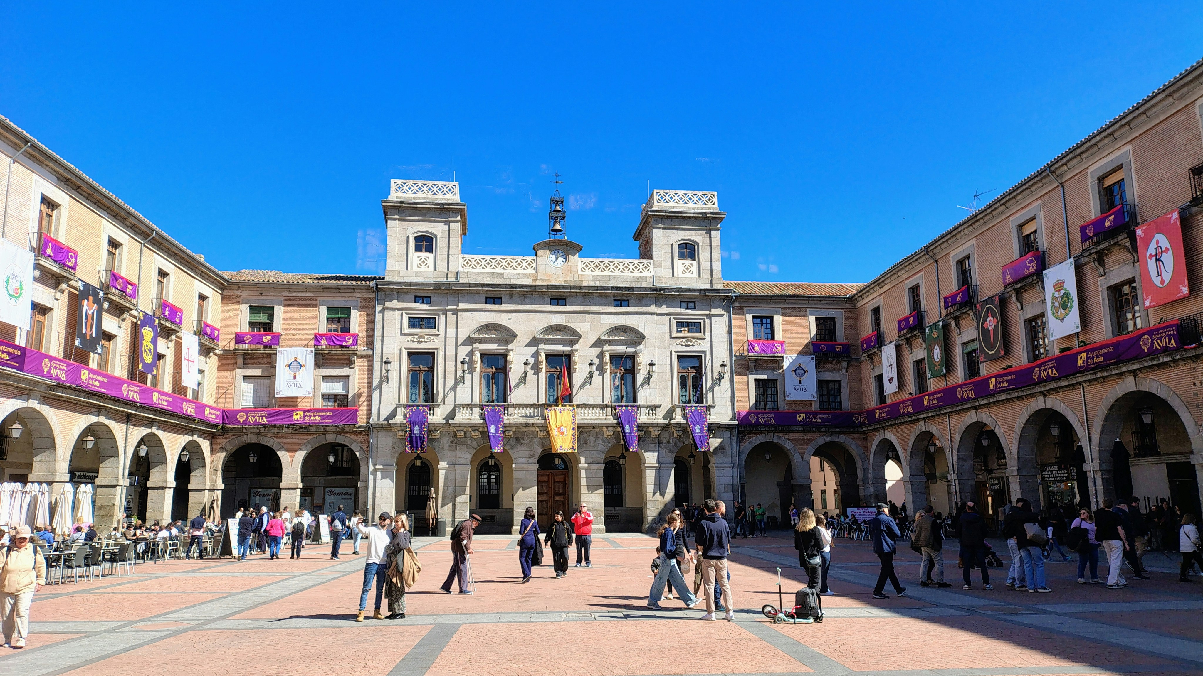 Central Plaza Bannered Facade: A Sunlit Courtyard With Purple Flags
