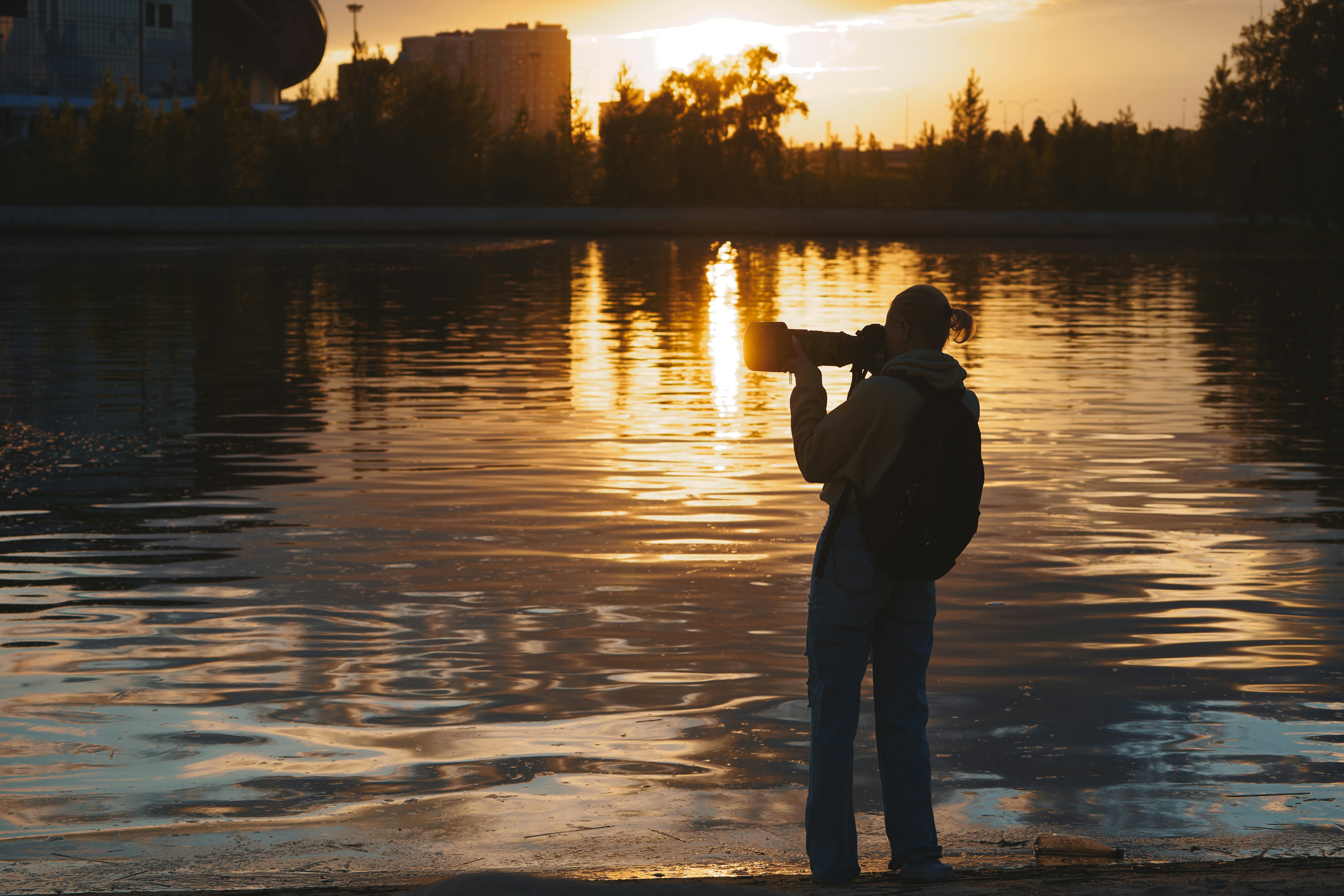 Silhouette Photographer at Sunset Over Calm Canal