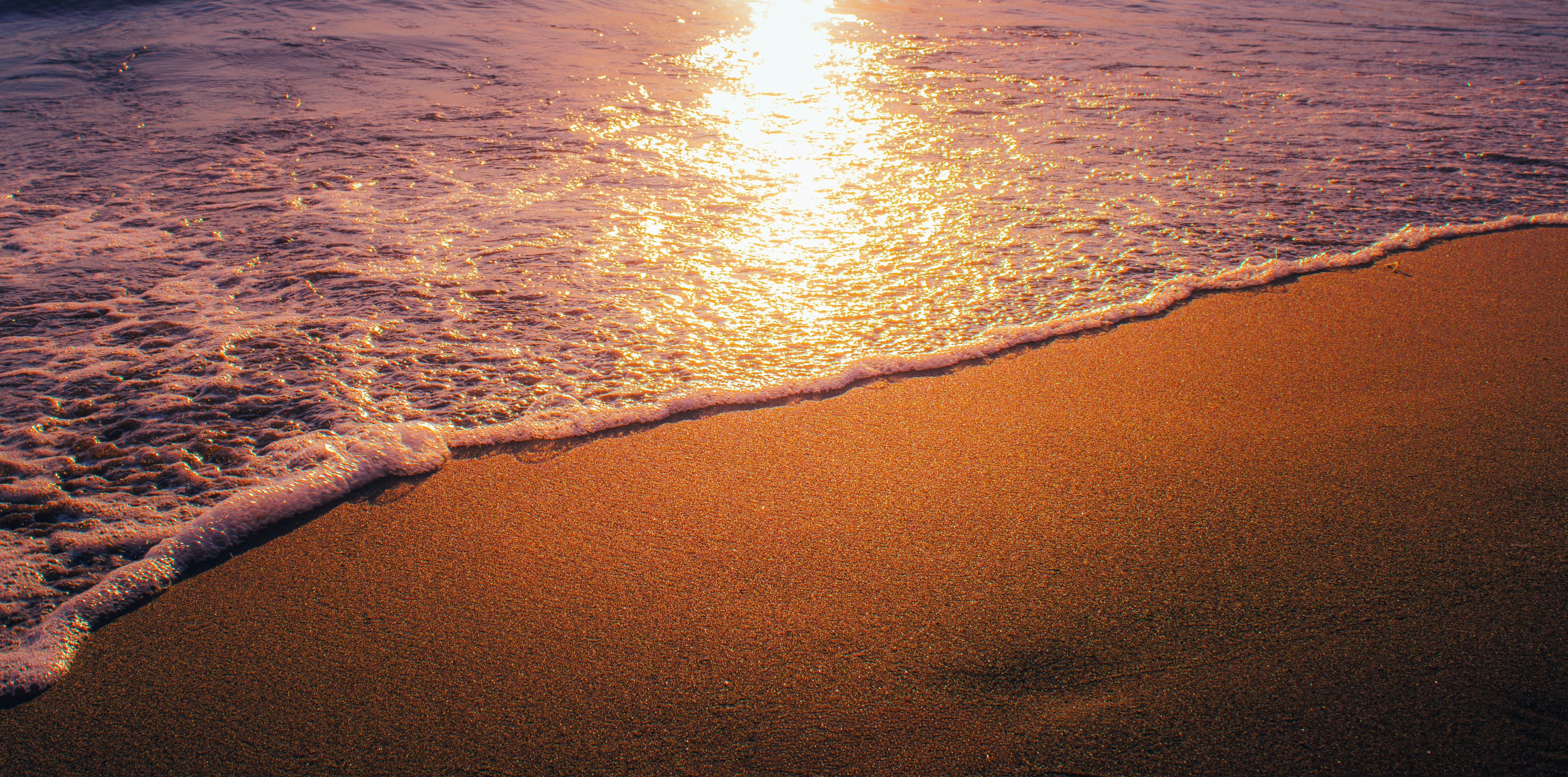 Sunlit Tide: A Quiet Shore with Golden Waves