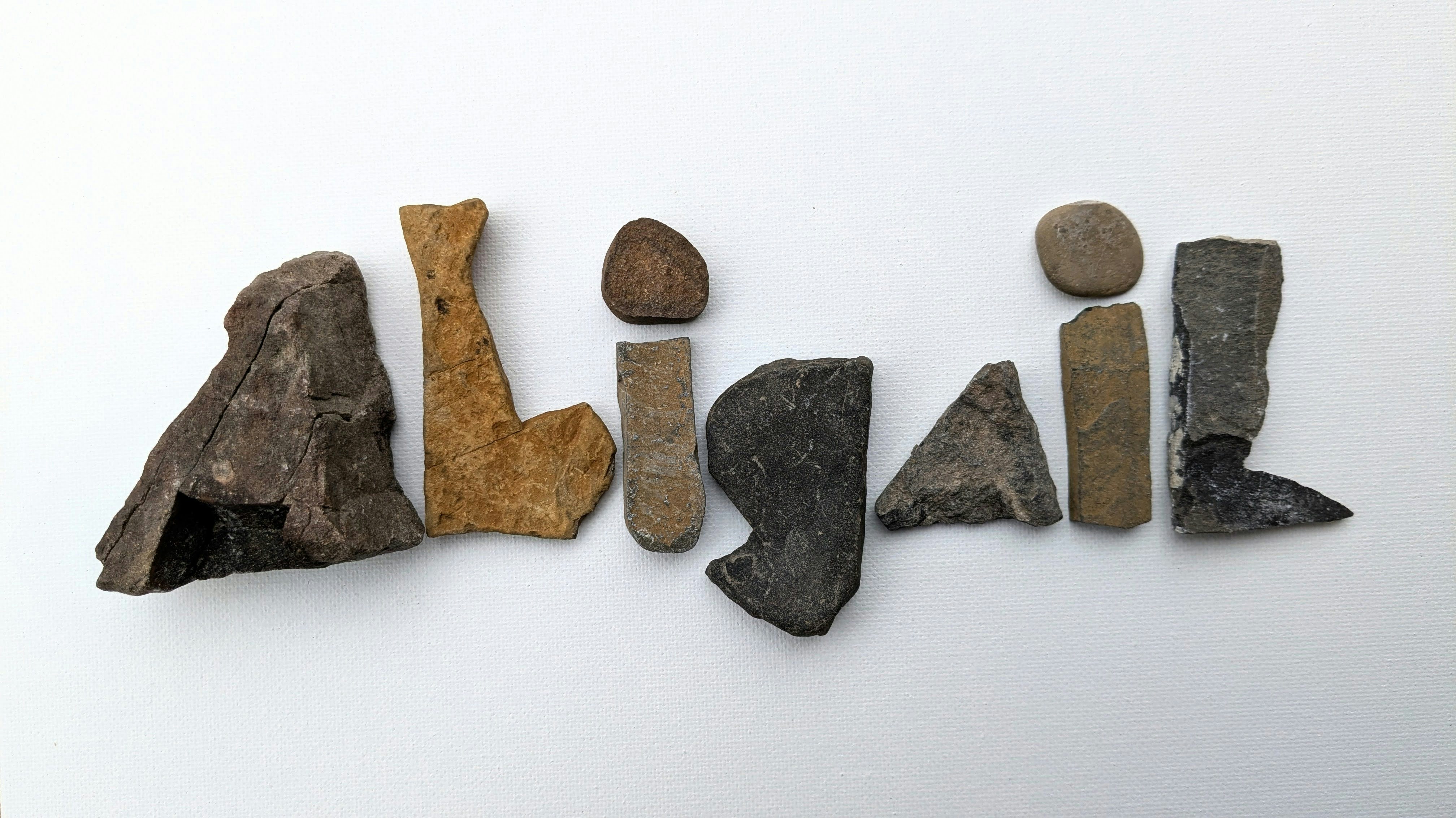 An arrangement of naturally fractured stones spelling out a name.