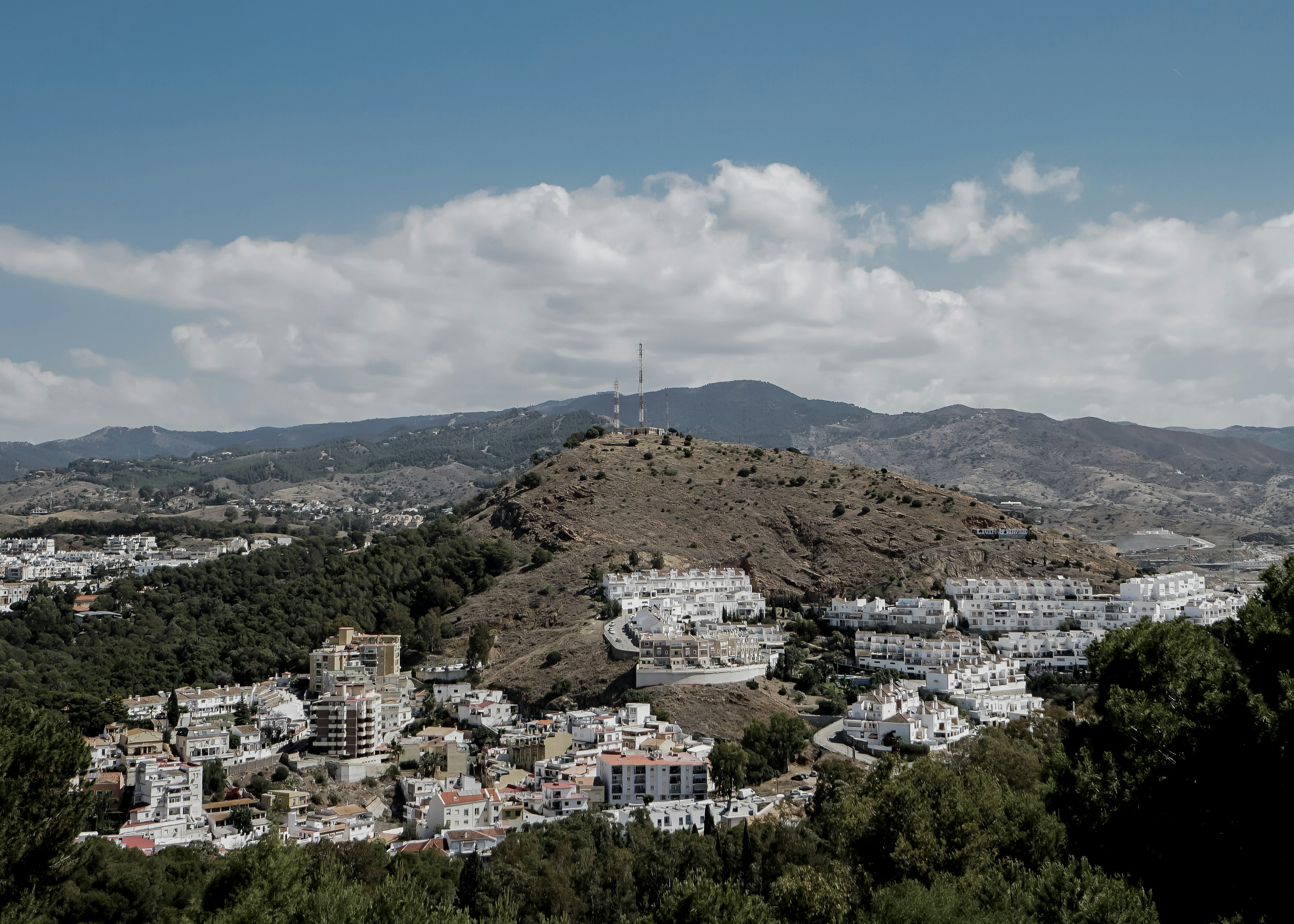 Hilltop Village under a Sky of Soft Clouds