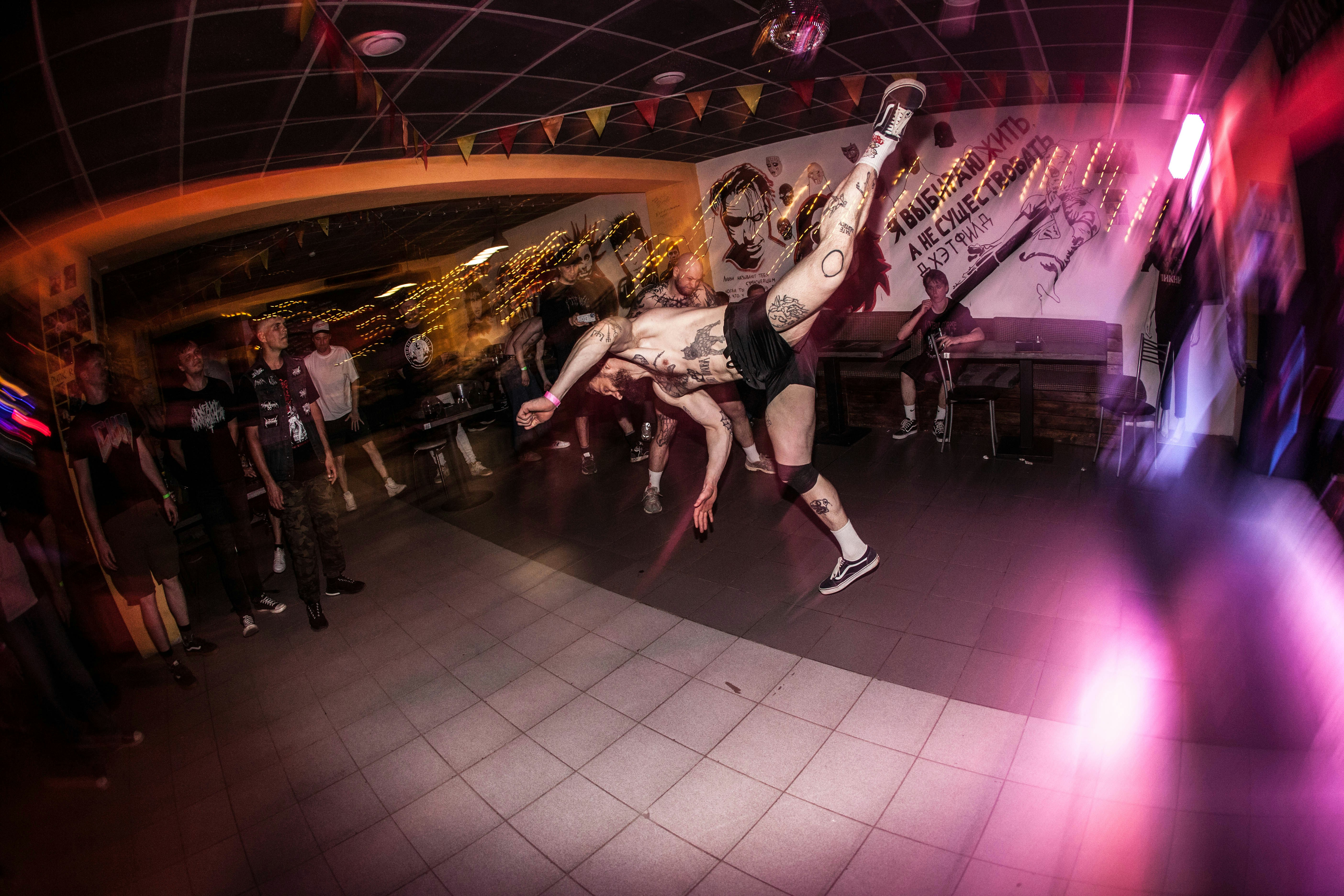 Midair Clash: Breakdancer’s Flight over a Neon Crowd
