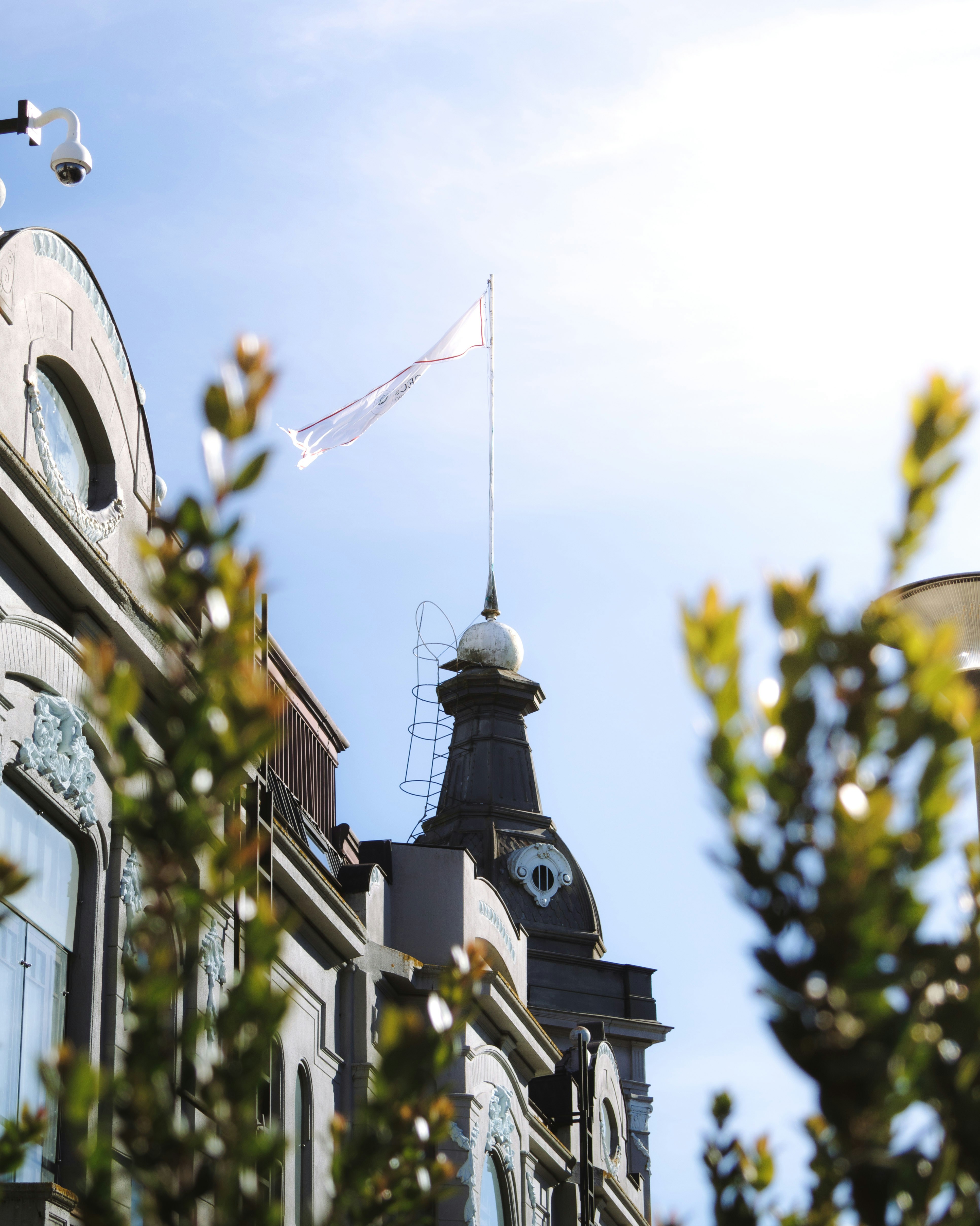 Turreted Facade under a Skylit Flag, Framing a City Hall Style Rooftop