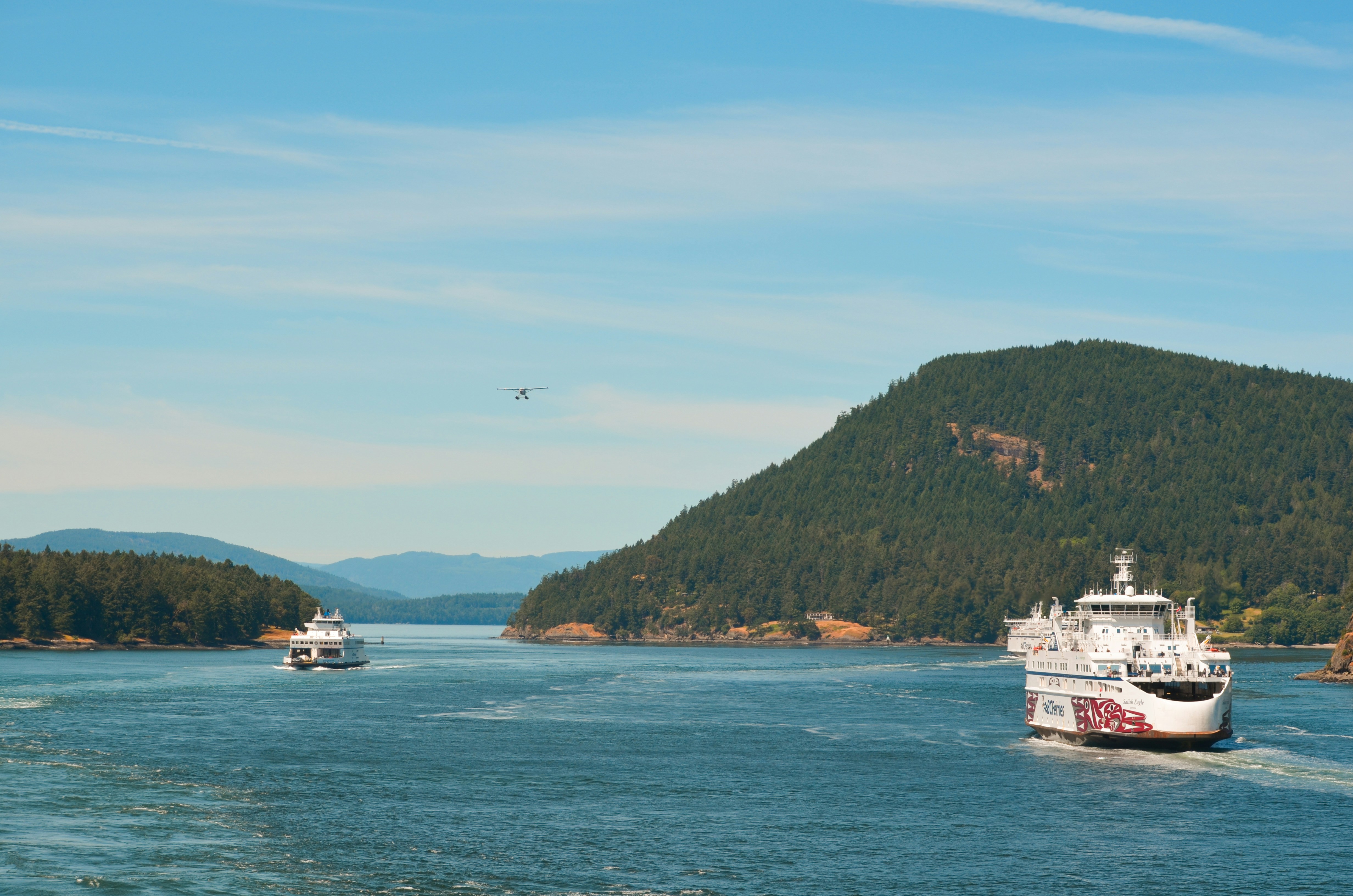 Opposing ferries carve a calm channel between forested hills