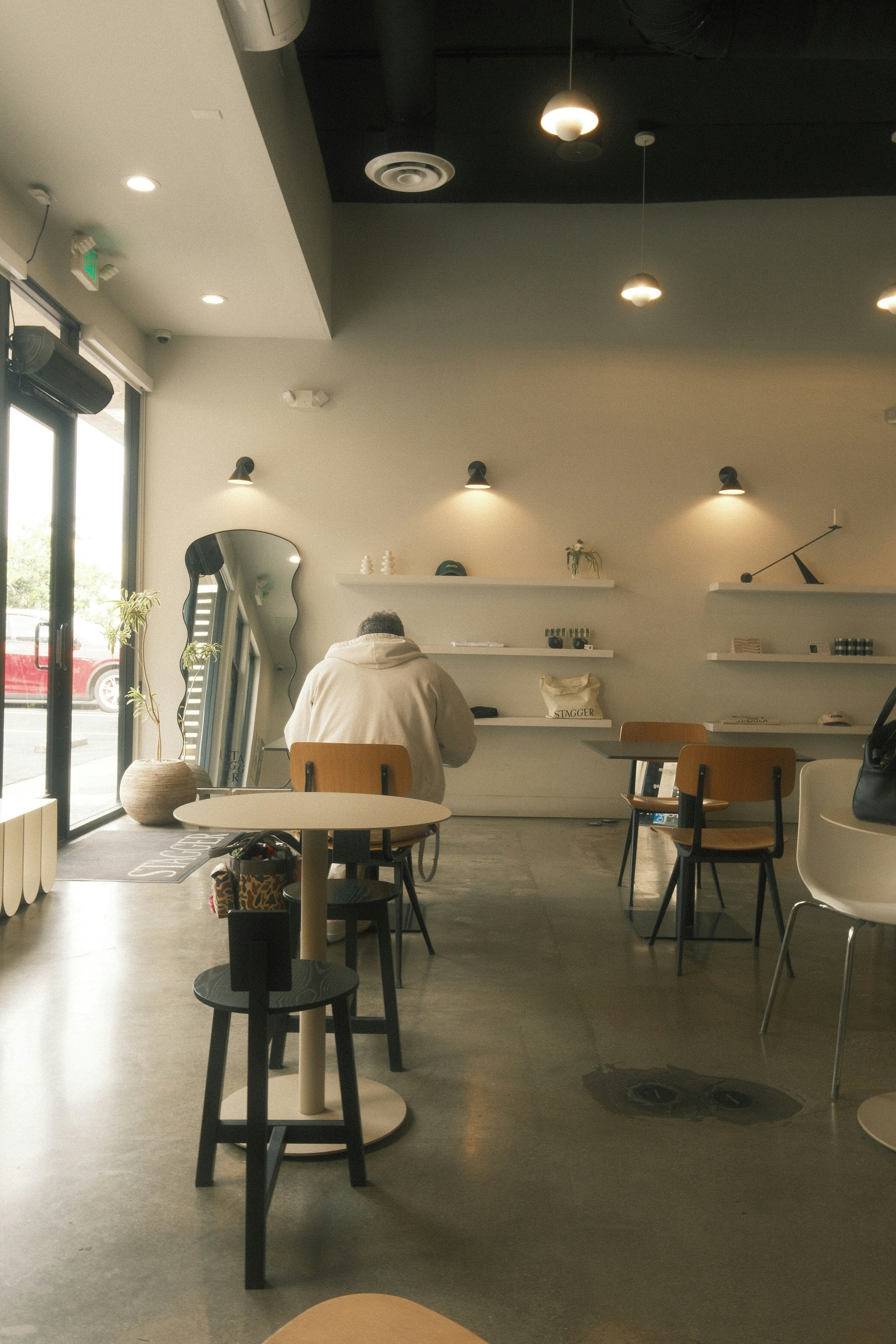 A person sits at a table in a modern cafe.