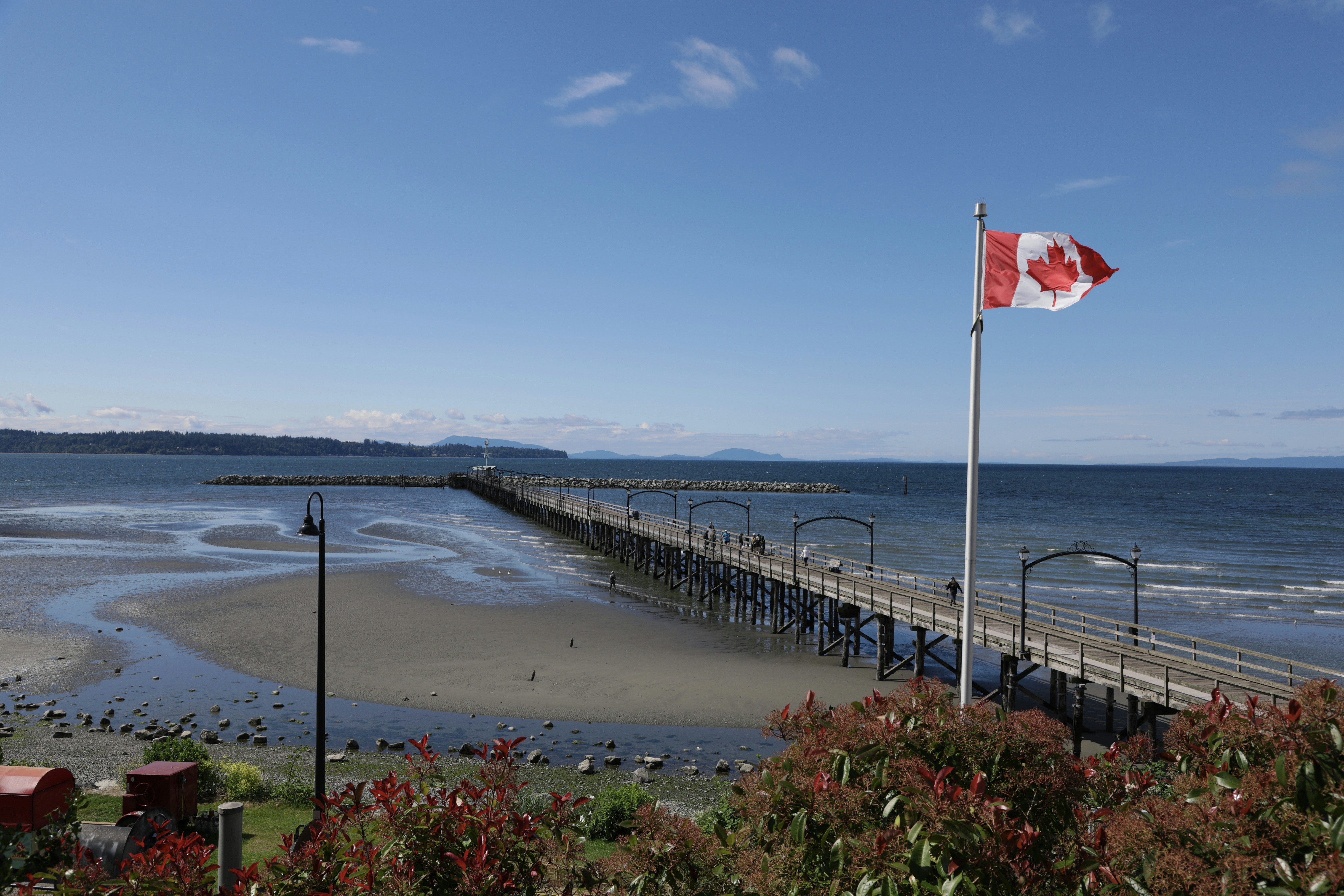 Flag Over the Quiet Pier: A Coastal Path to the Horizon