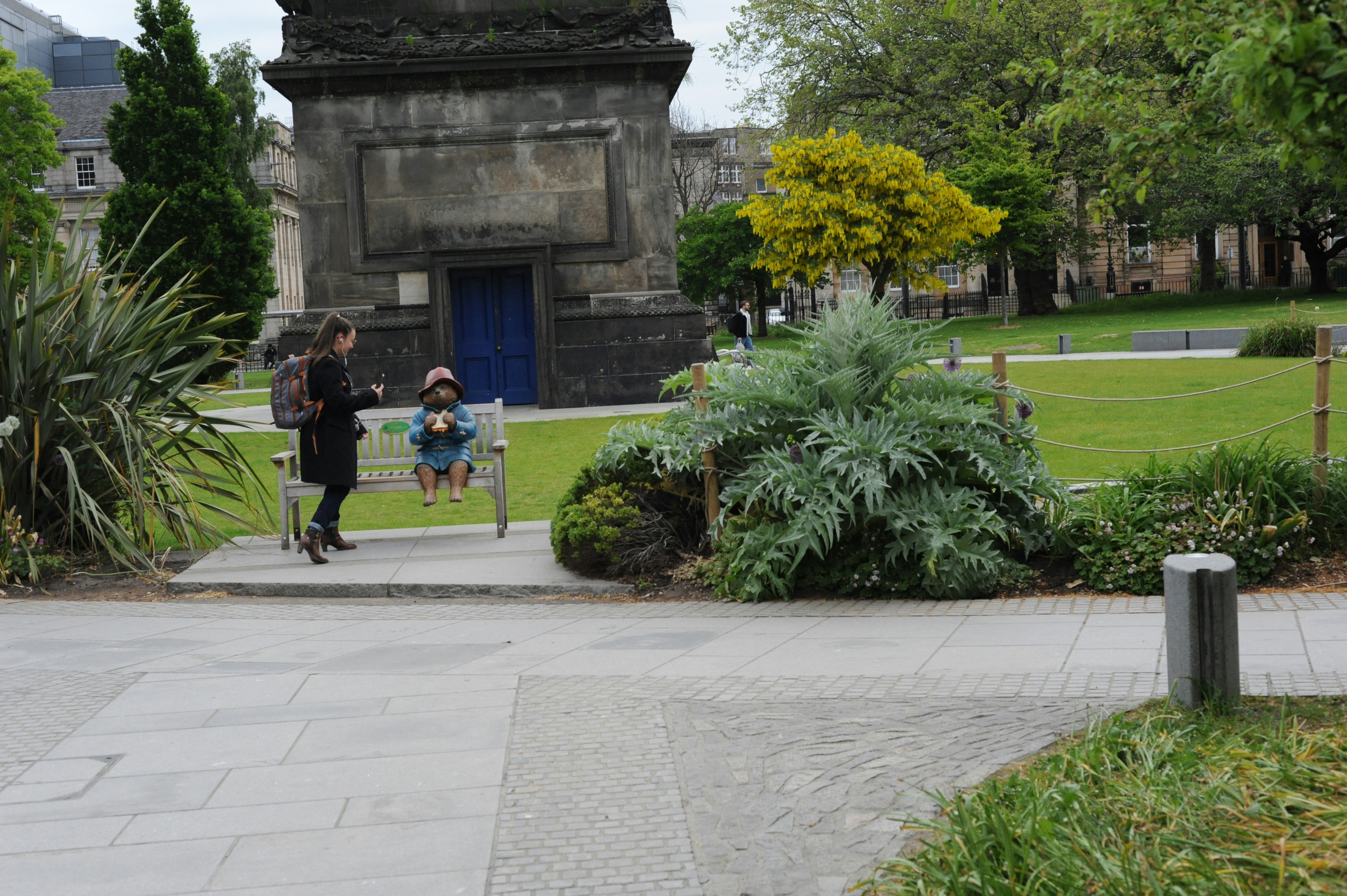Children on a Park Bench near a Monument