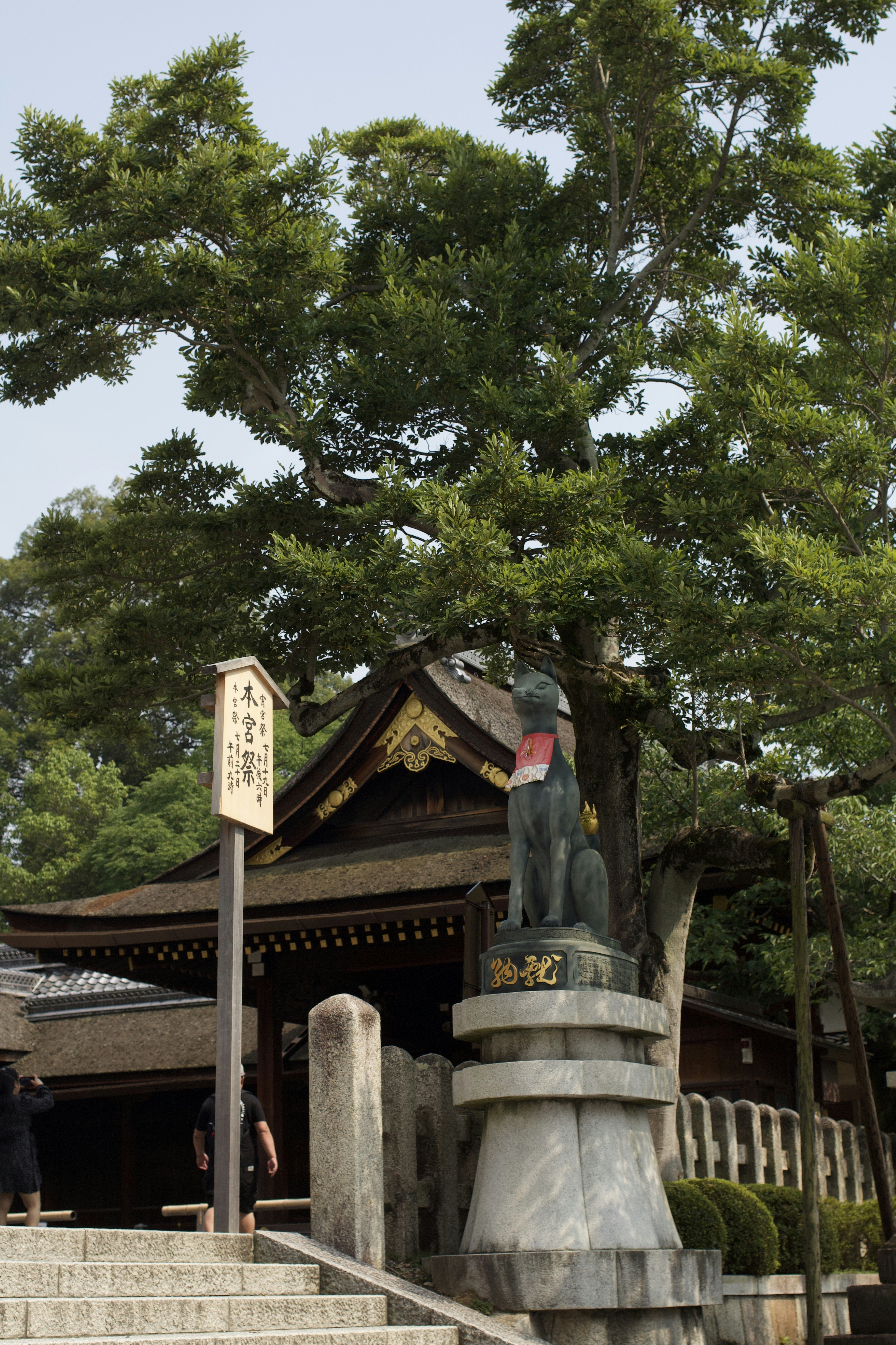 Stone Fox Statue Guards the Shrine Steps Under a Broad Canopy