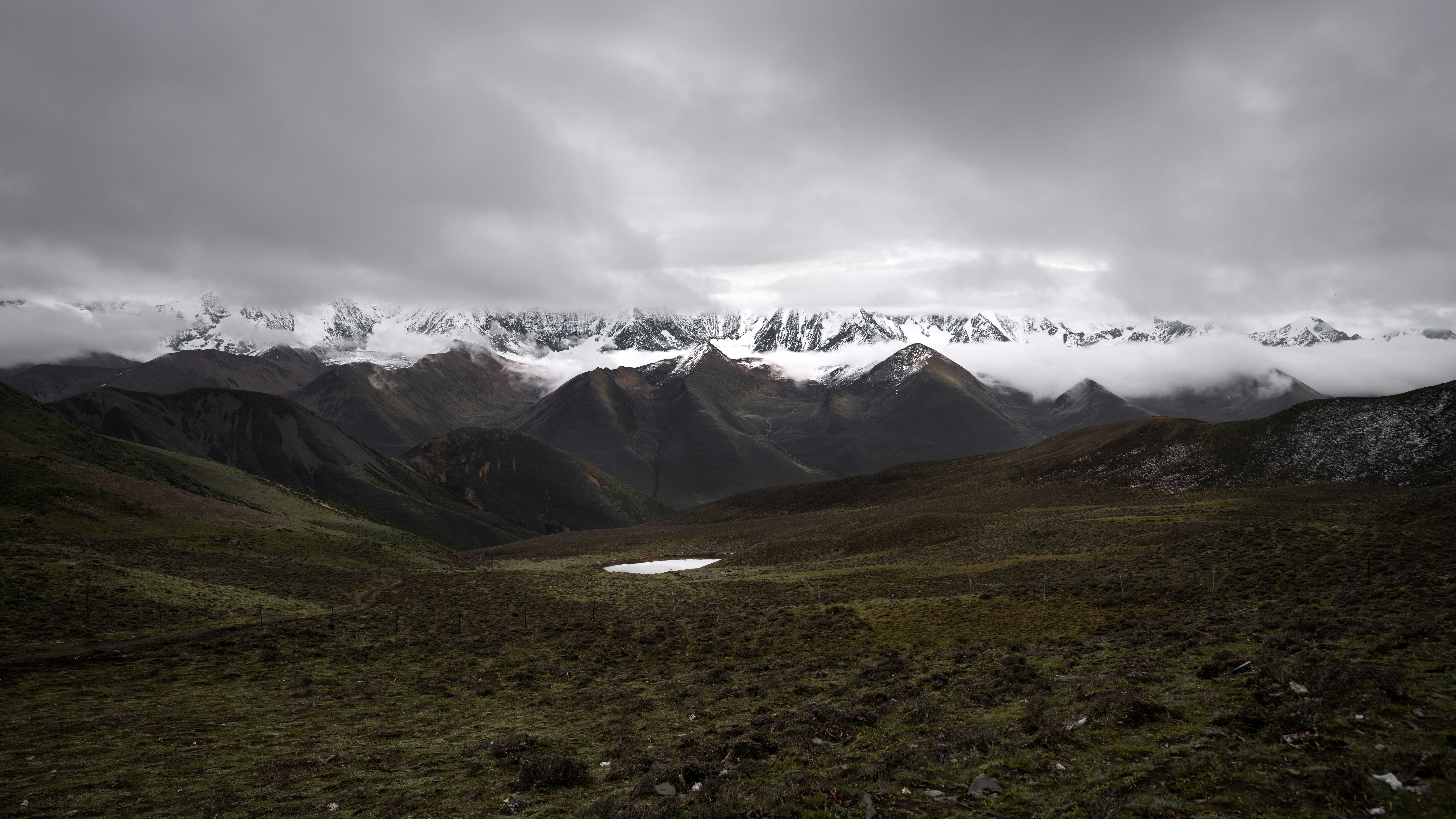 Cloud-shrouded alpine ridge over a quiet tundra