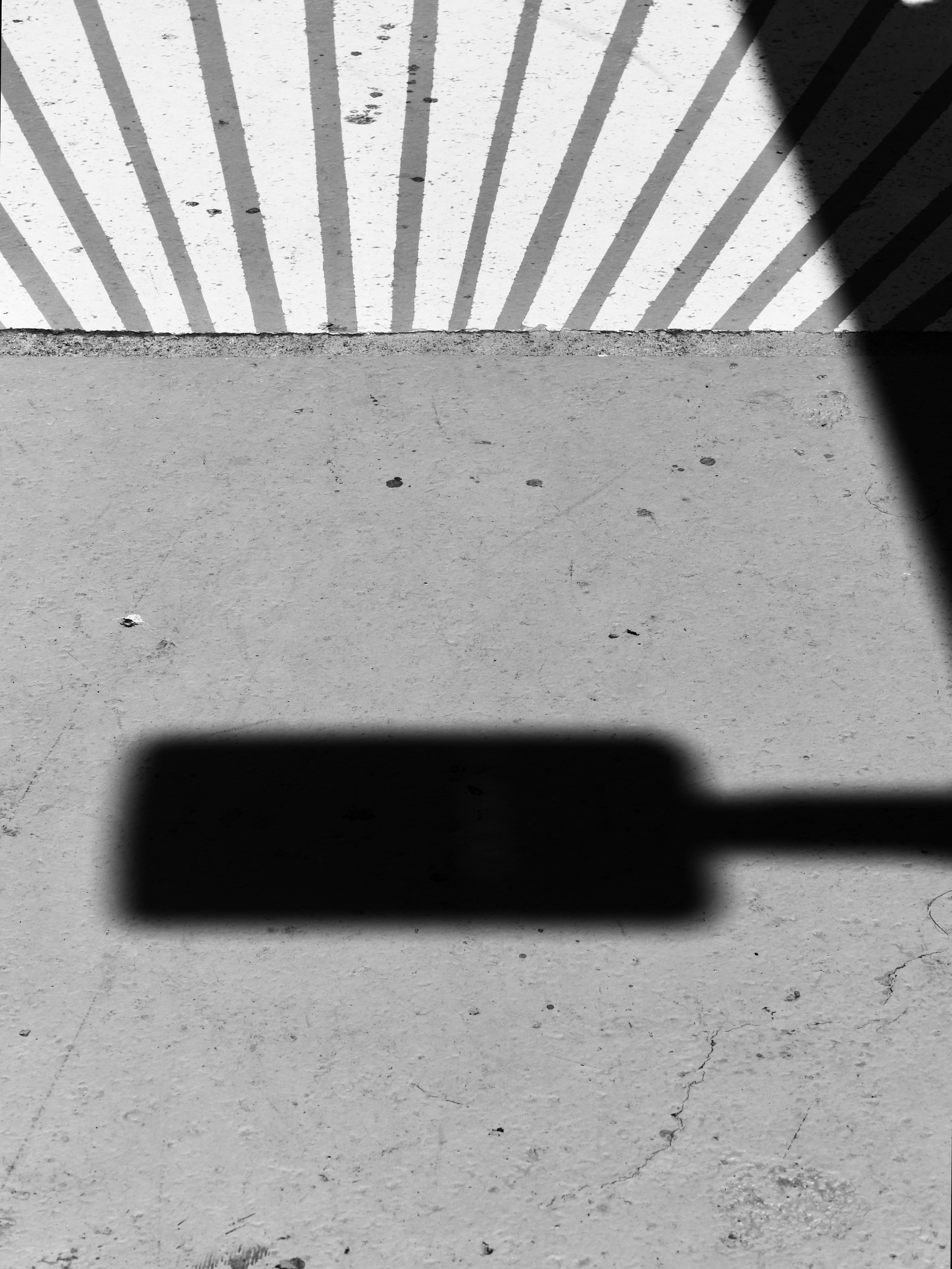 Shadowed Utility: A Concrete Moment Cast by a Striped Fencing Shadow