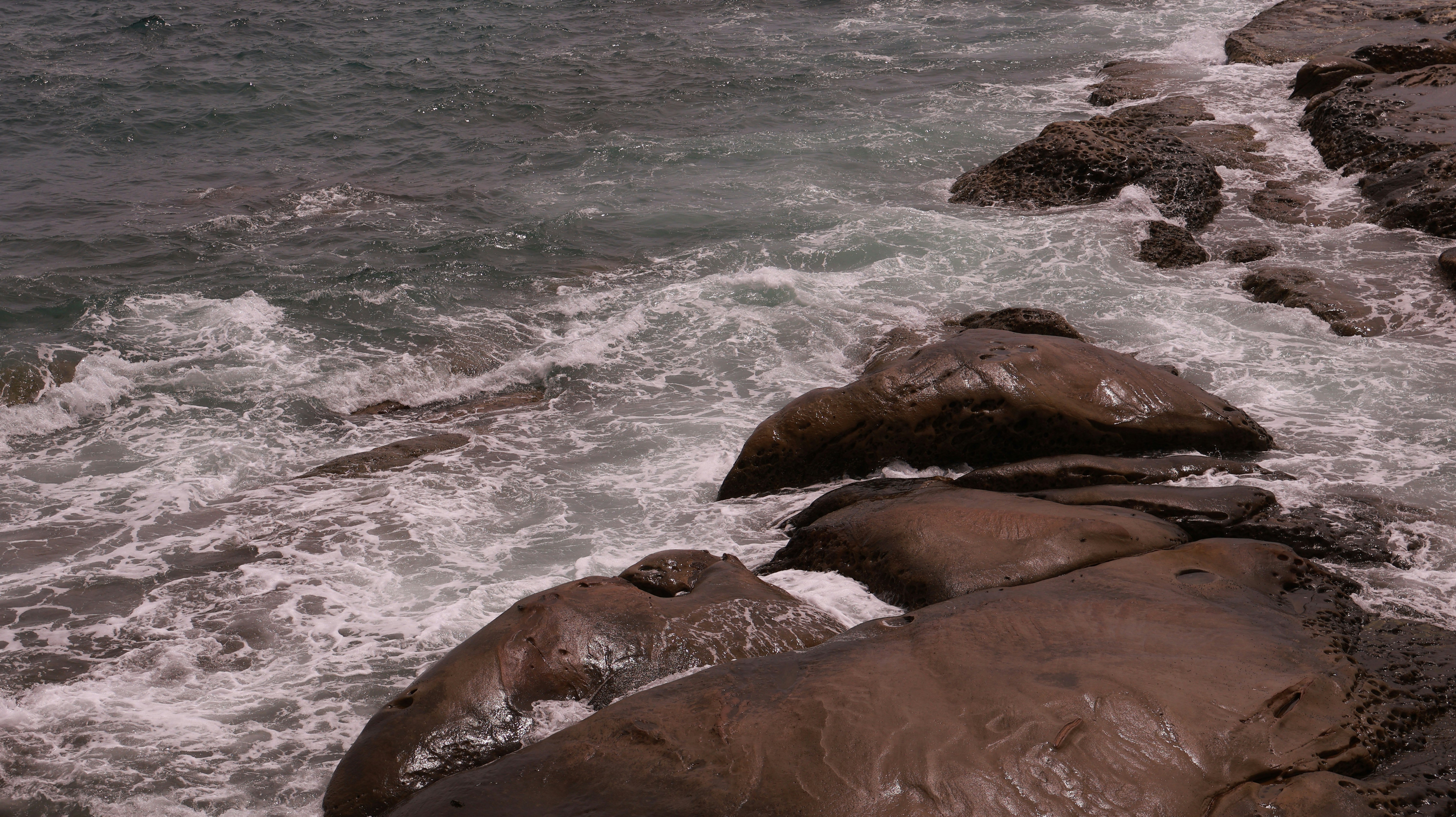 Rugged shoreline overrun by rolling sea and weathered stones