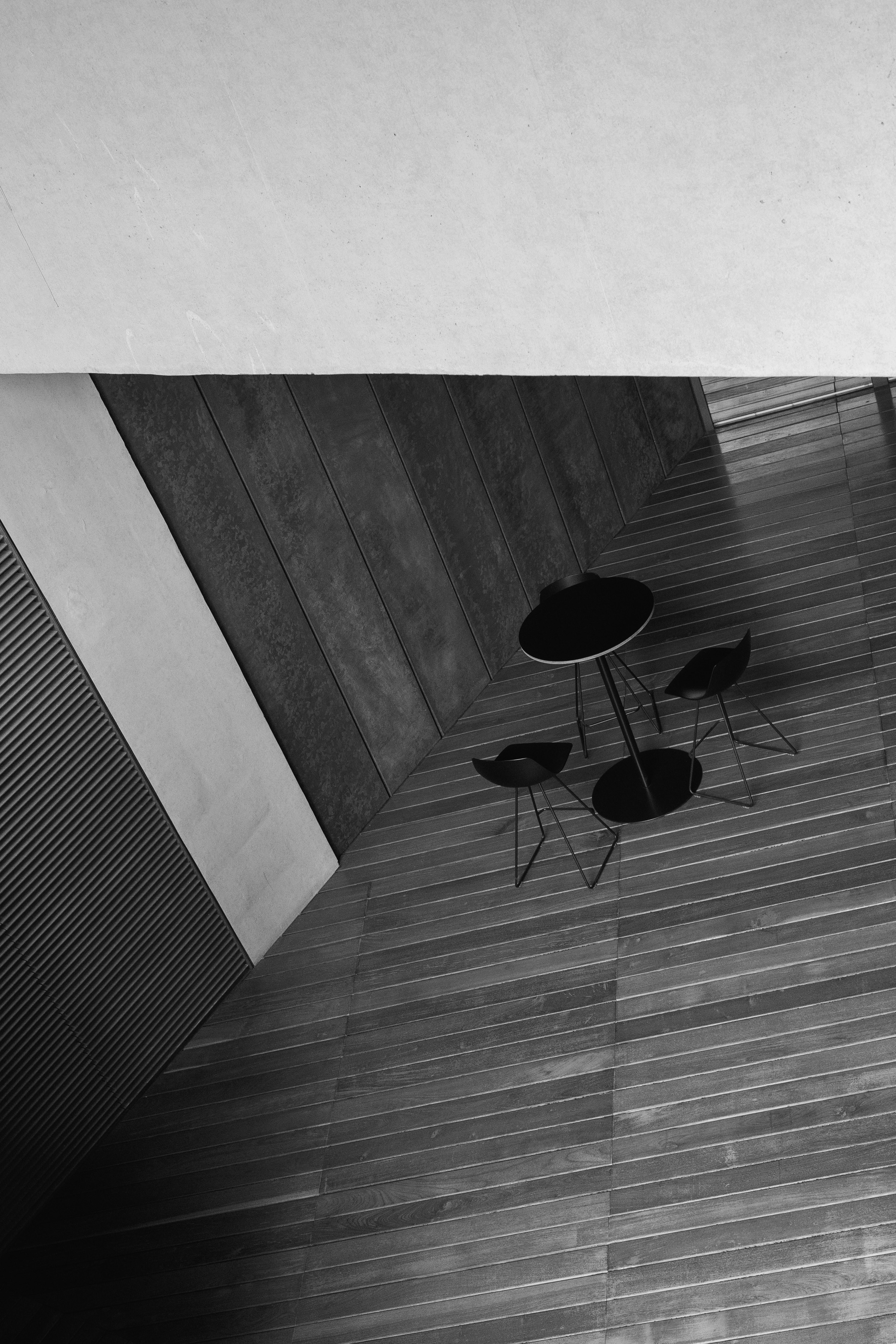 Monochromatic interior with minimalist table and chairs on wooden floor.