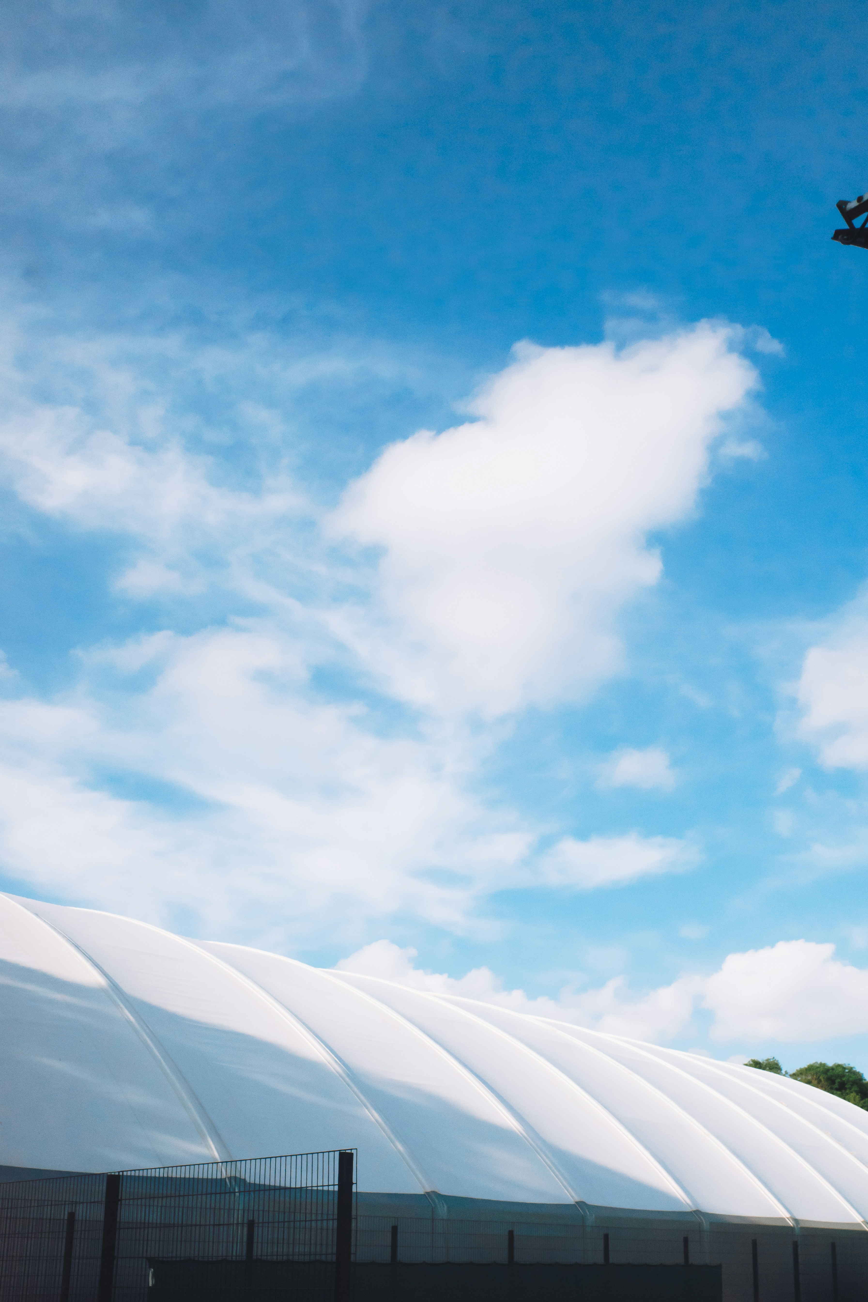 Curved white canopies under a bright sky